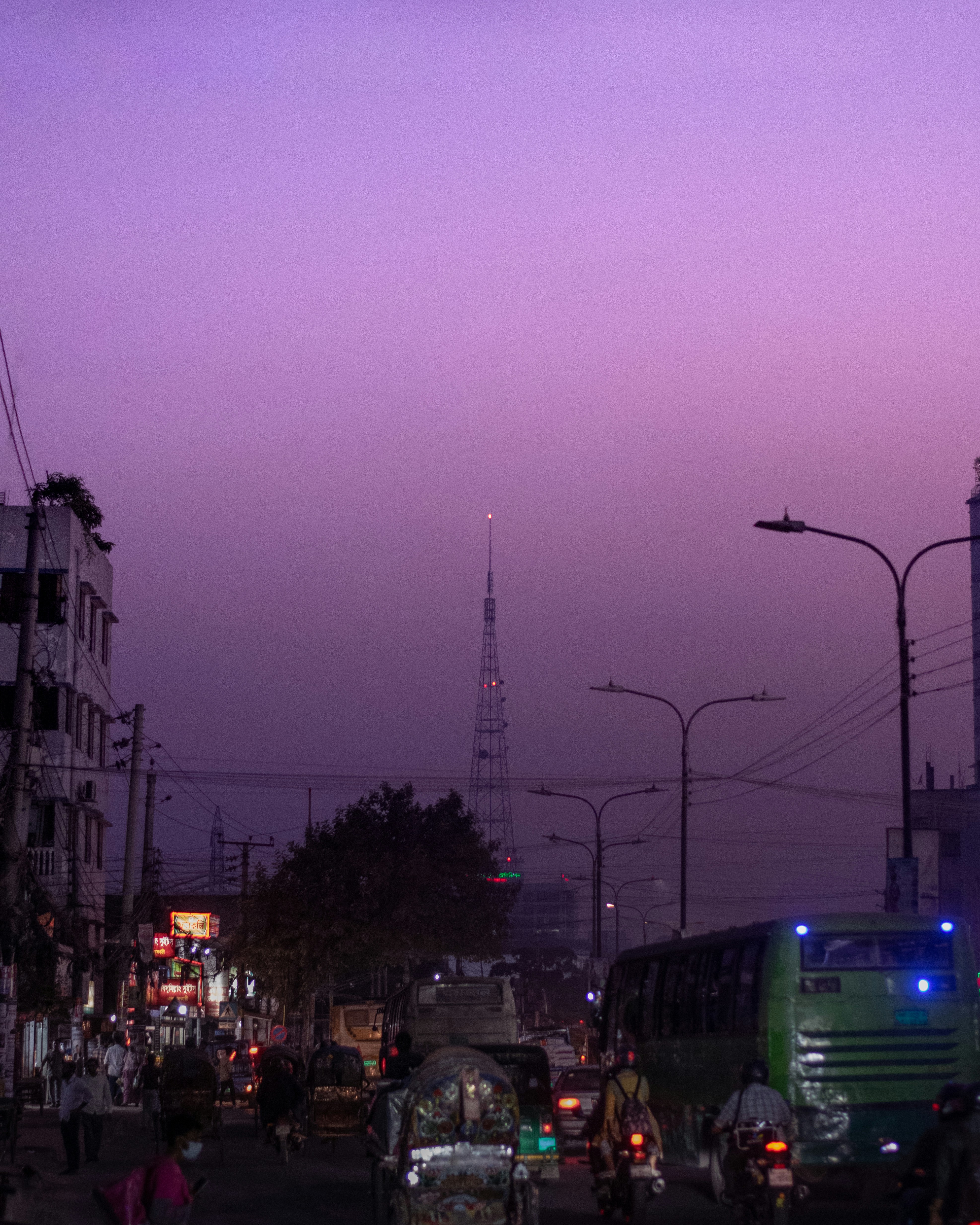 Violet Dusk Over a Bustling City Street and a Distant Radio Tower