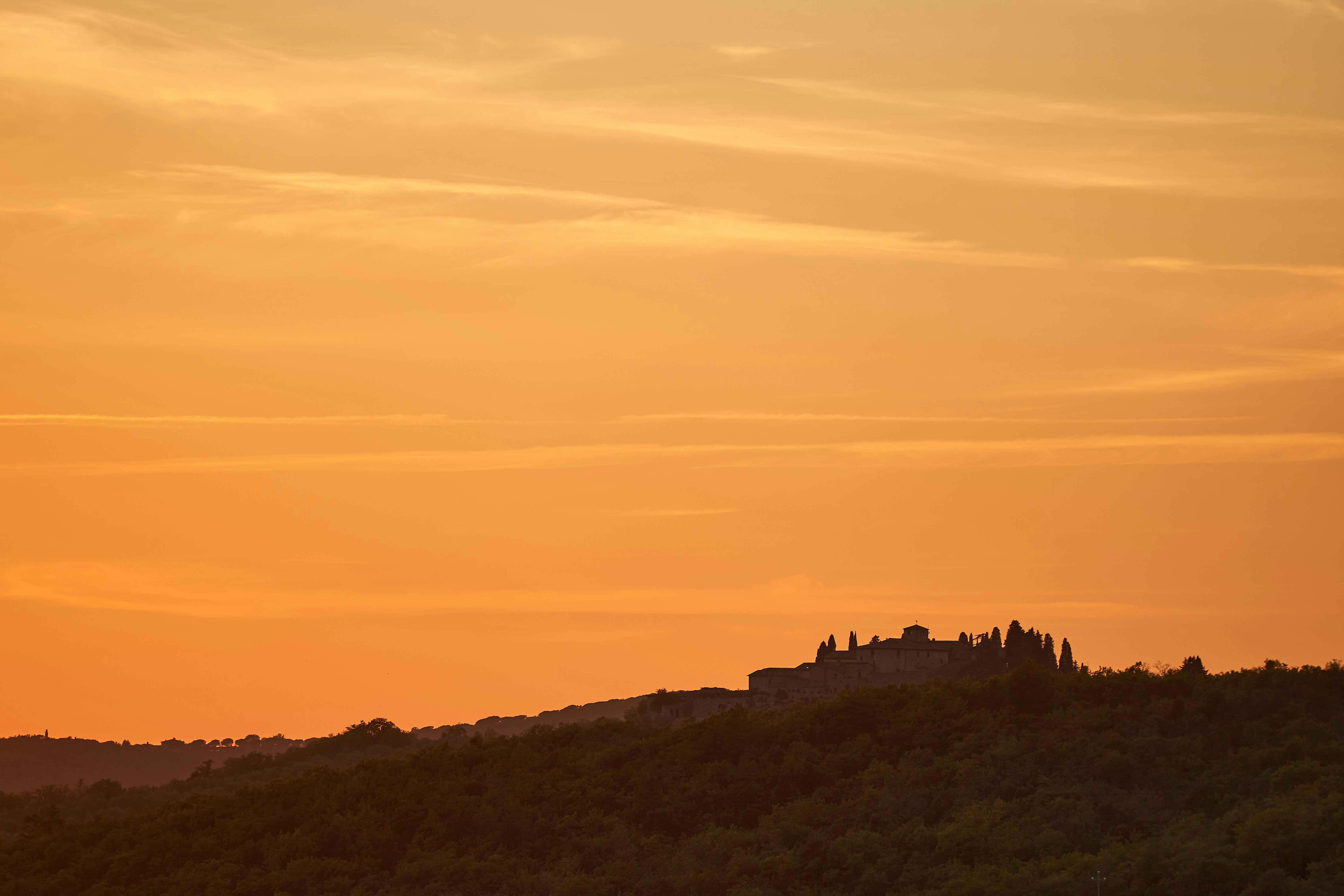 The sun is setting over a hill with a castle on it photo – Free ...