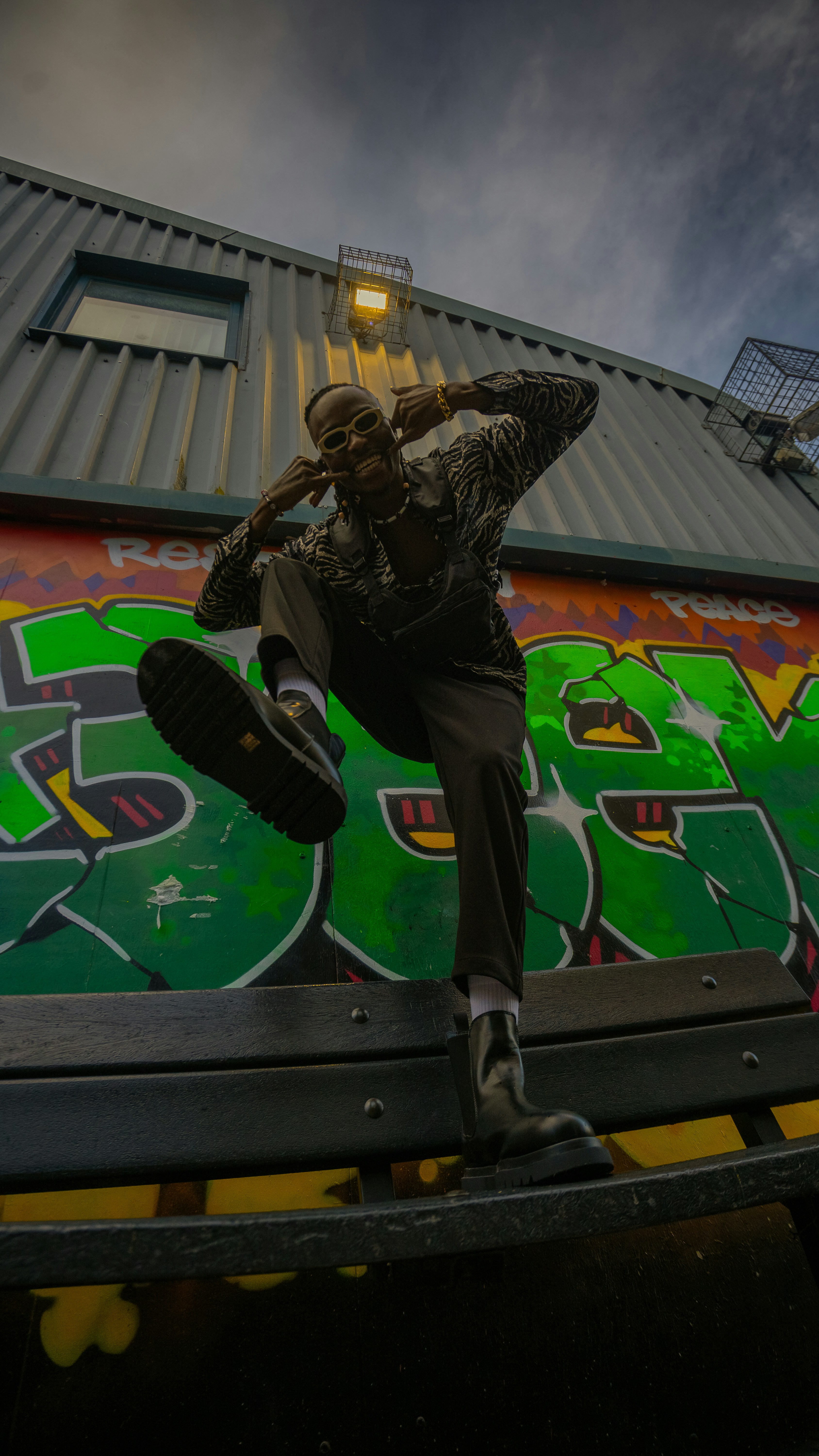 Graffiti Stage Kick: A Bold Portrait Against Neon Brick
