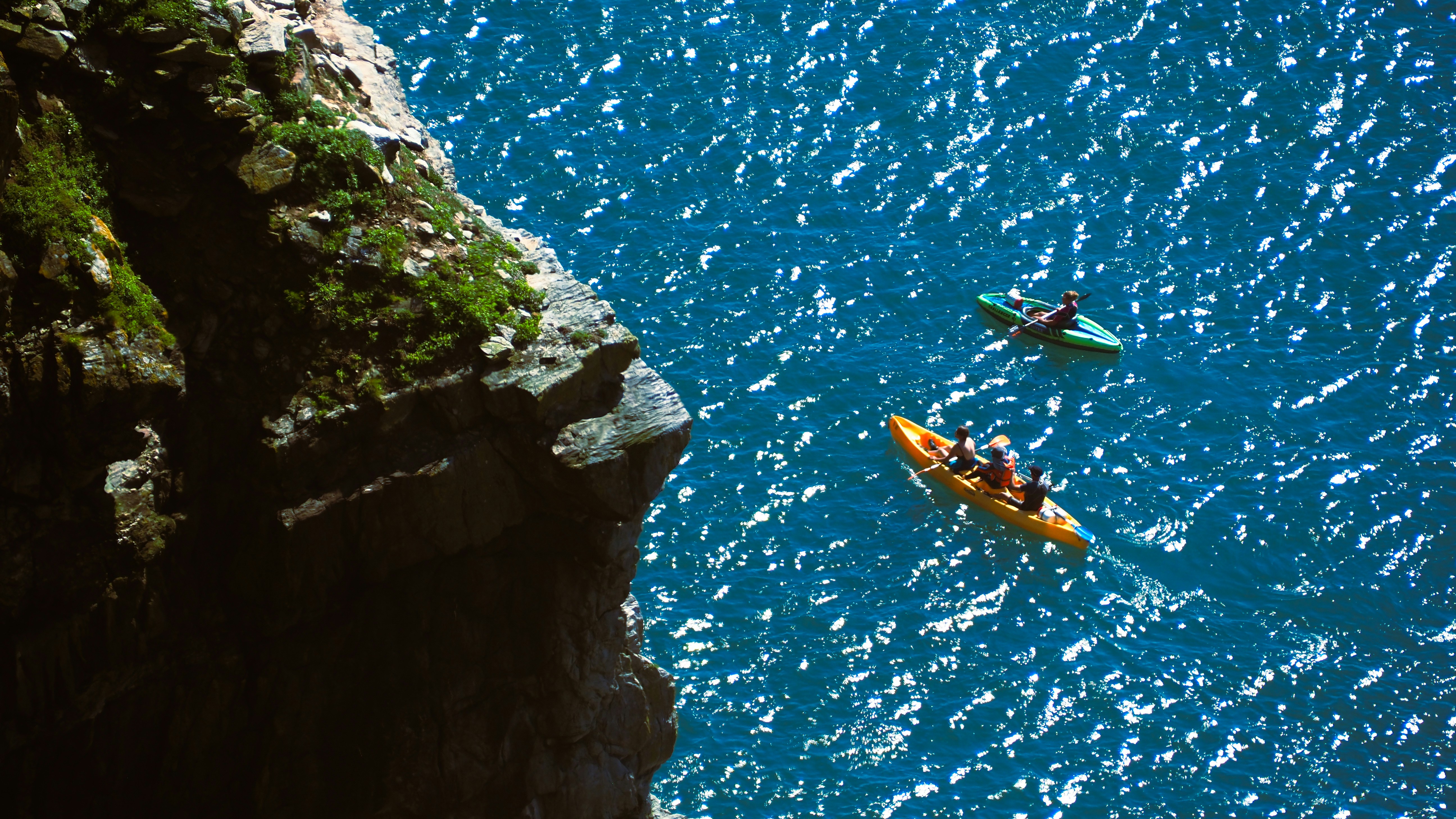 A couple of people in a kayak on a body of water photo – Free Anglesea ...