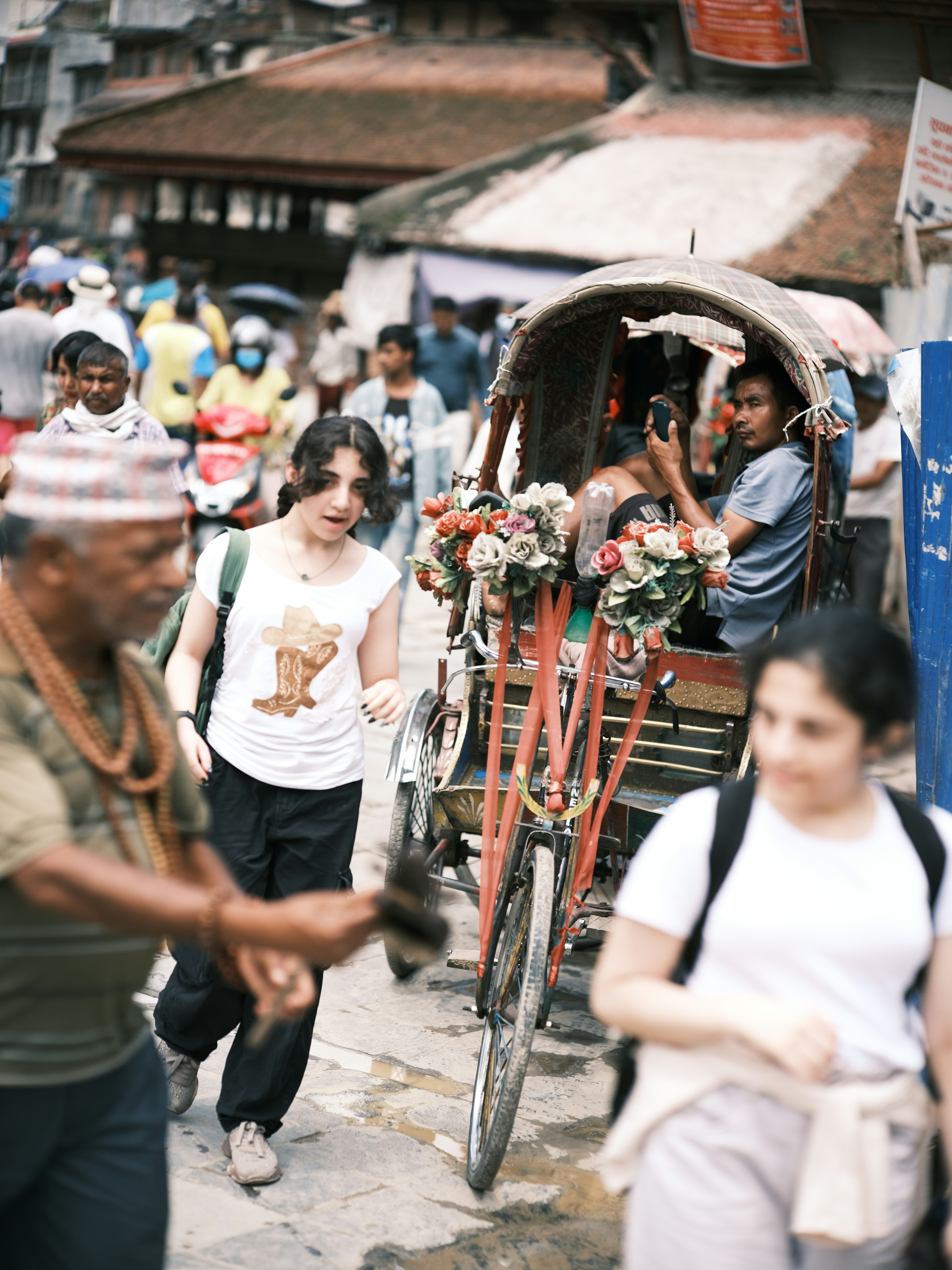 Jostled Street Moment: A Floral Cart Framed by Passing Faces