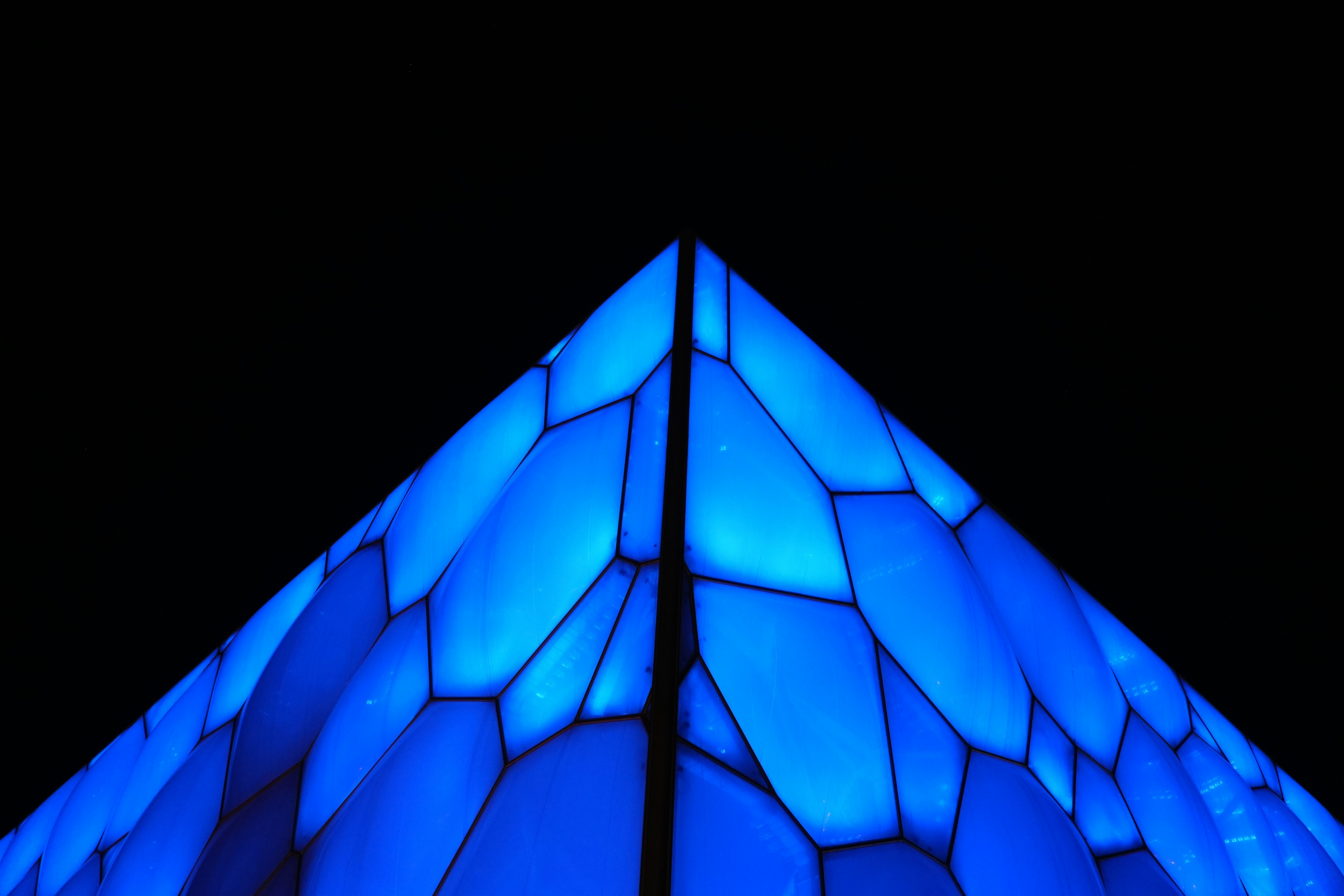 Apex of Blue Facets: Night-Illuminated Geometric Pyramid