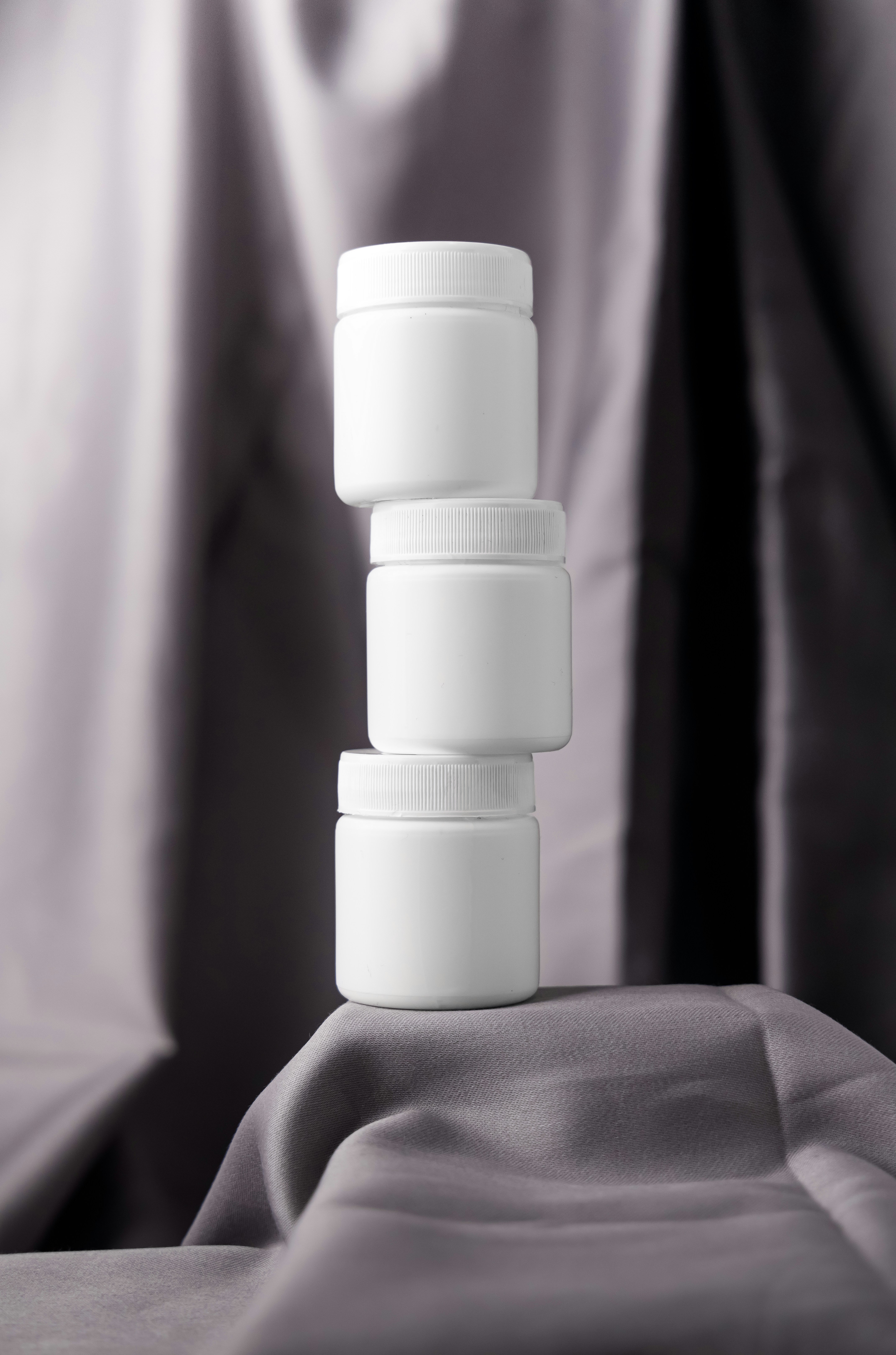 A stack of white pills sitting on top of a bed photo – Free Silk Image ...