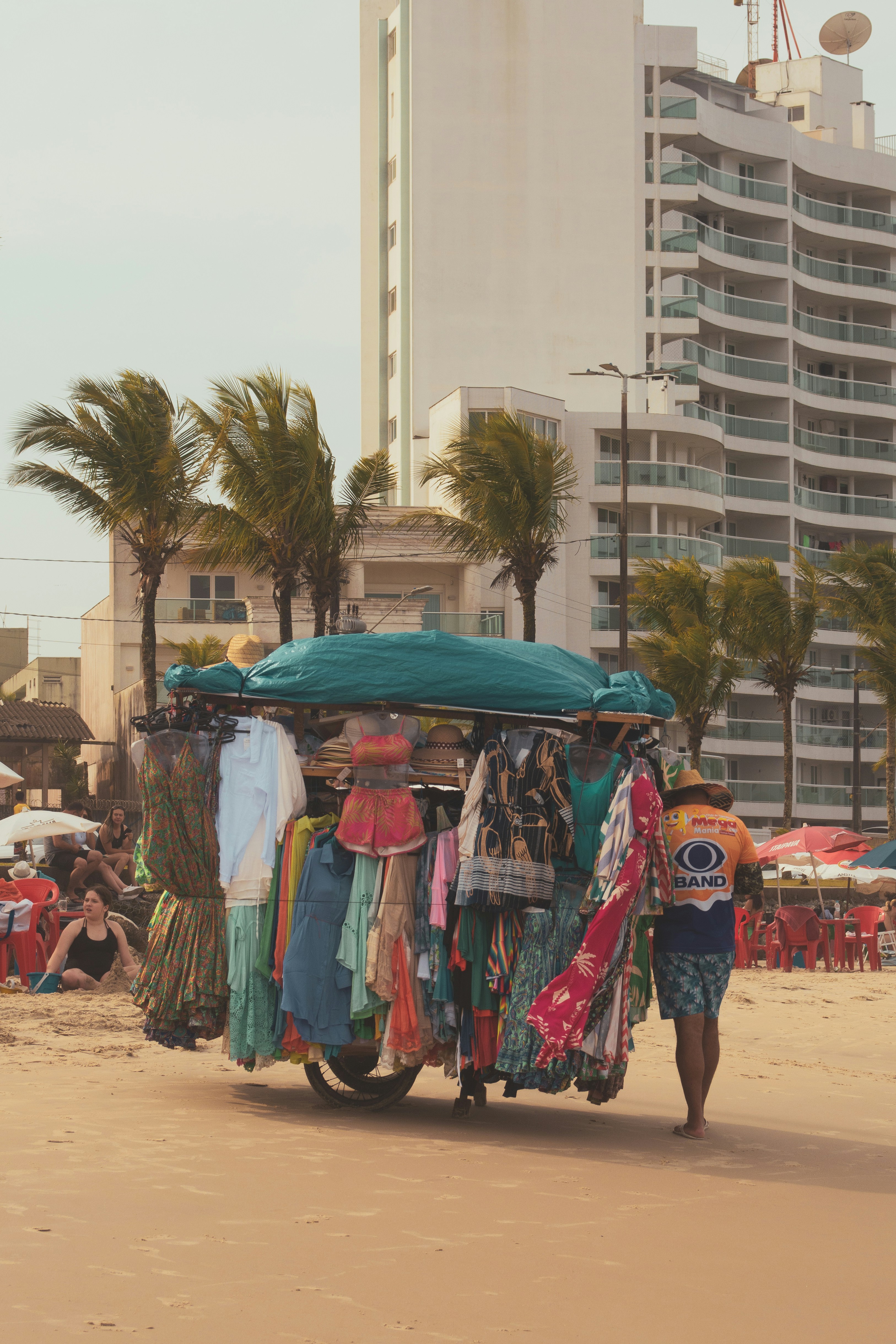 Caravan of Color: Beachfront Clothing Cart Under a Turquoise Canopy