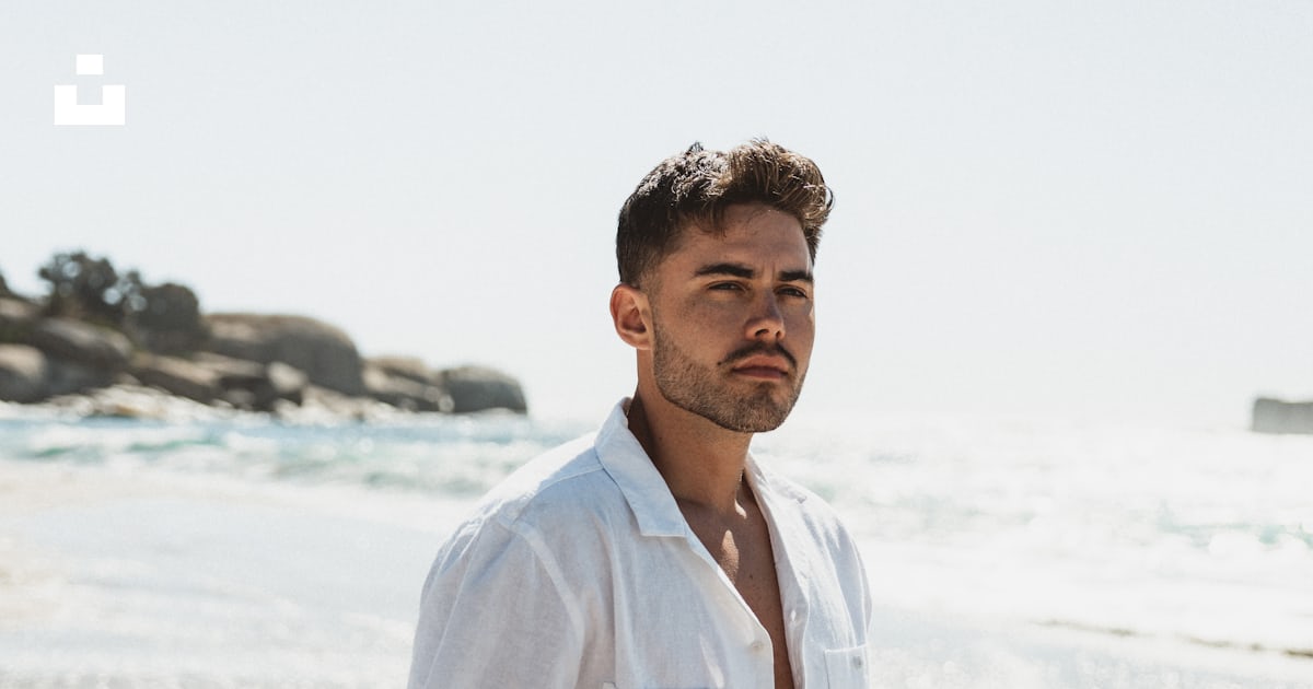 Un Hombre Parado En Una Playa Junto Al Océano Foto Imagen De Hombre