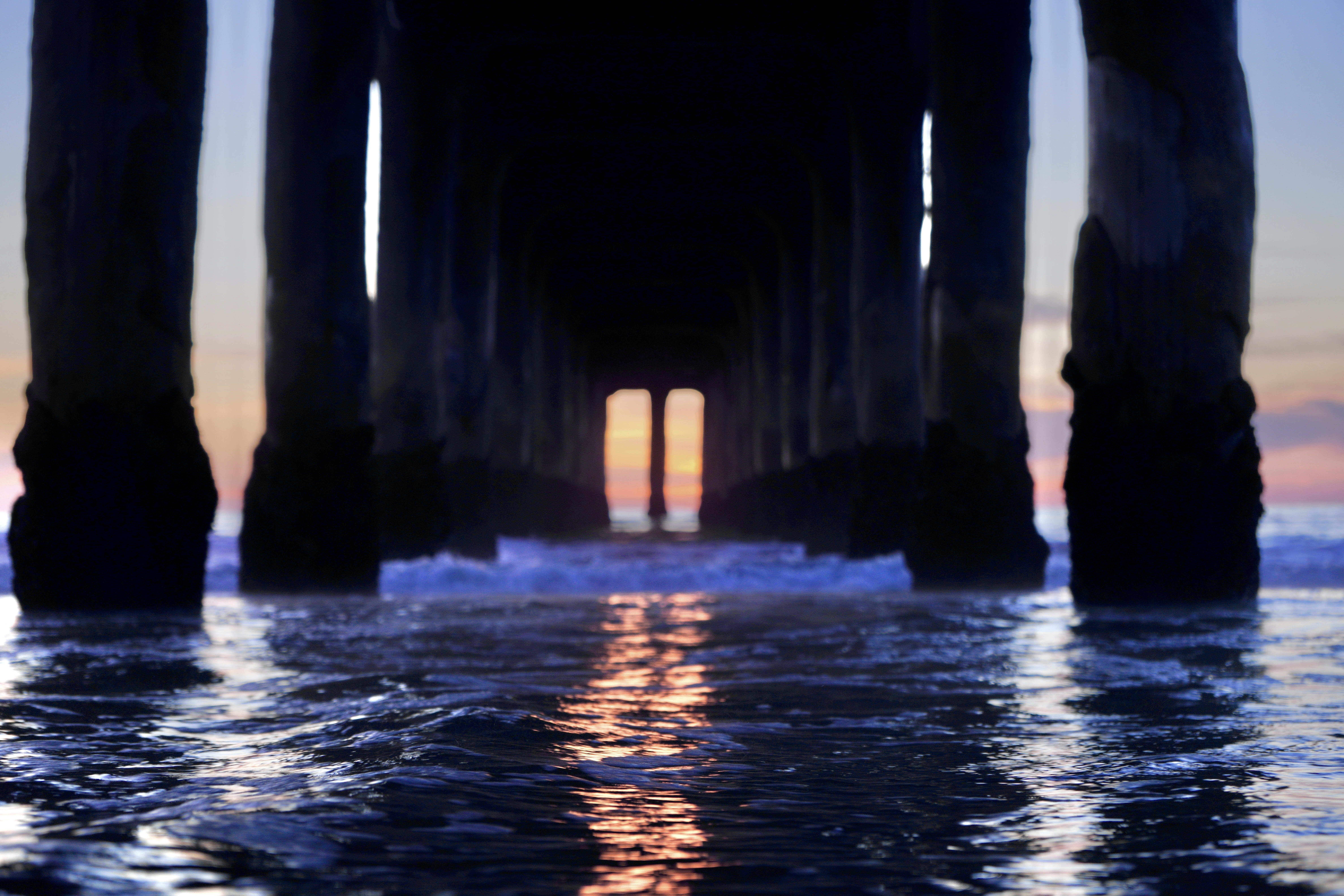 Foto zum Thema Blick auf das Meer unter einem Pier bei Sonnenuntergang ...