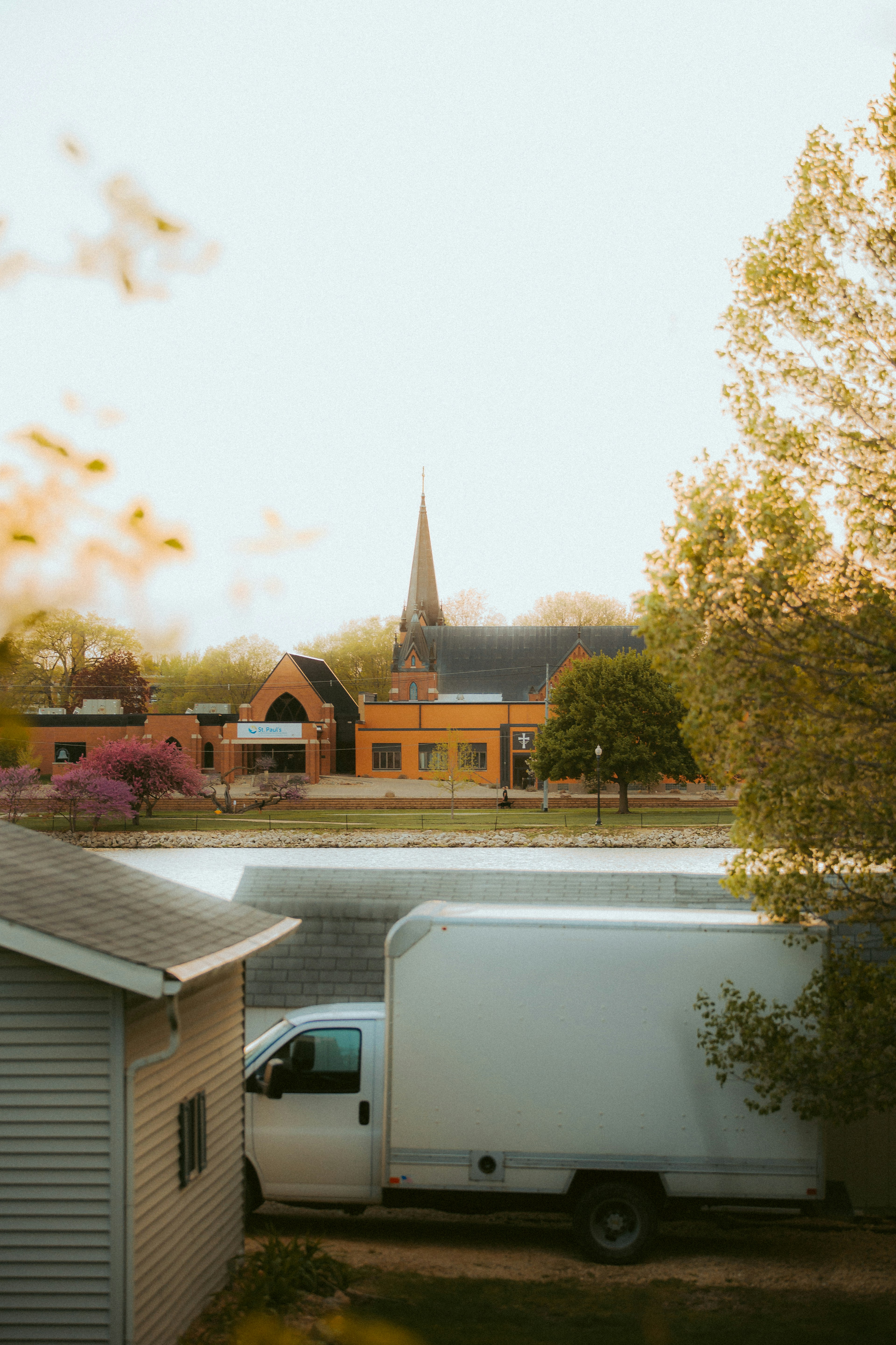 Sunlit Townscape: Steeple Over the Quiet Riverside