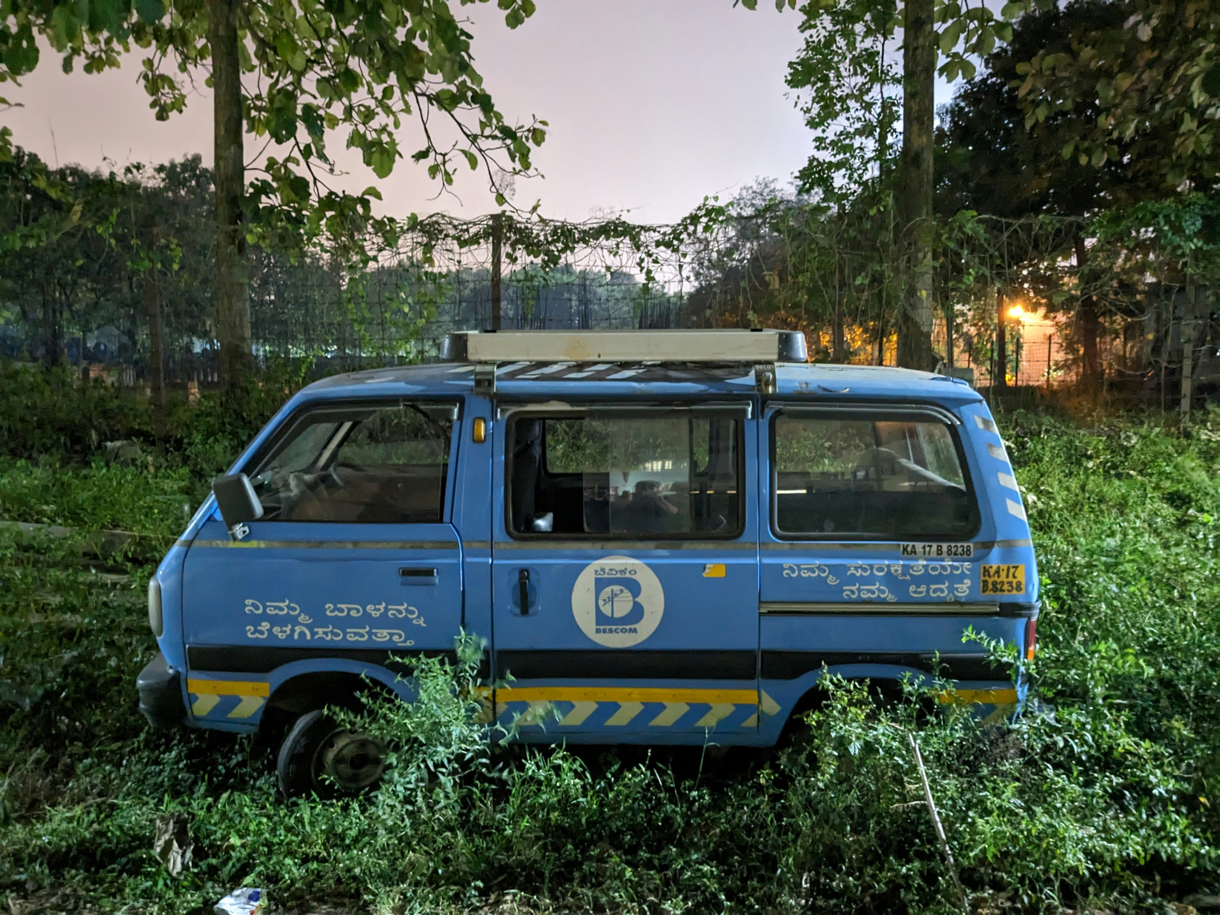 Blue Service Van Emerges from the Green Verge at Dusk