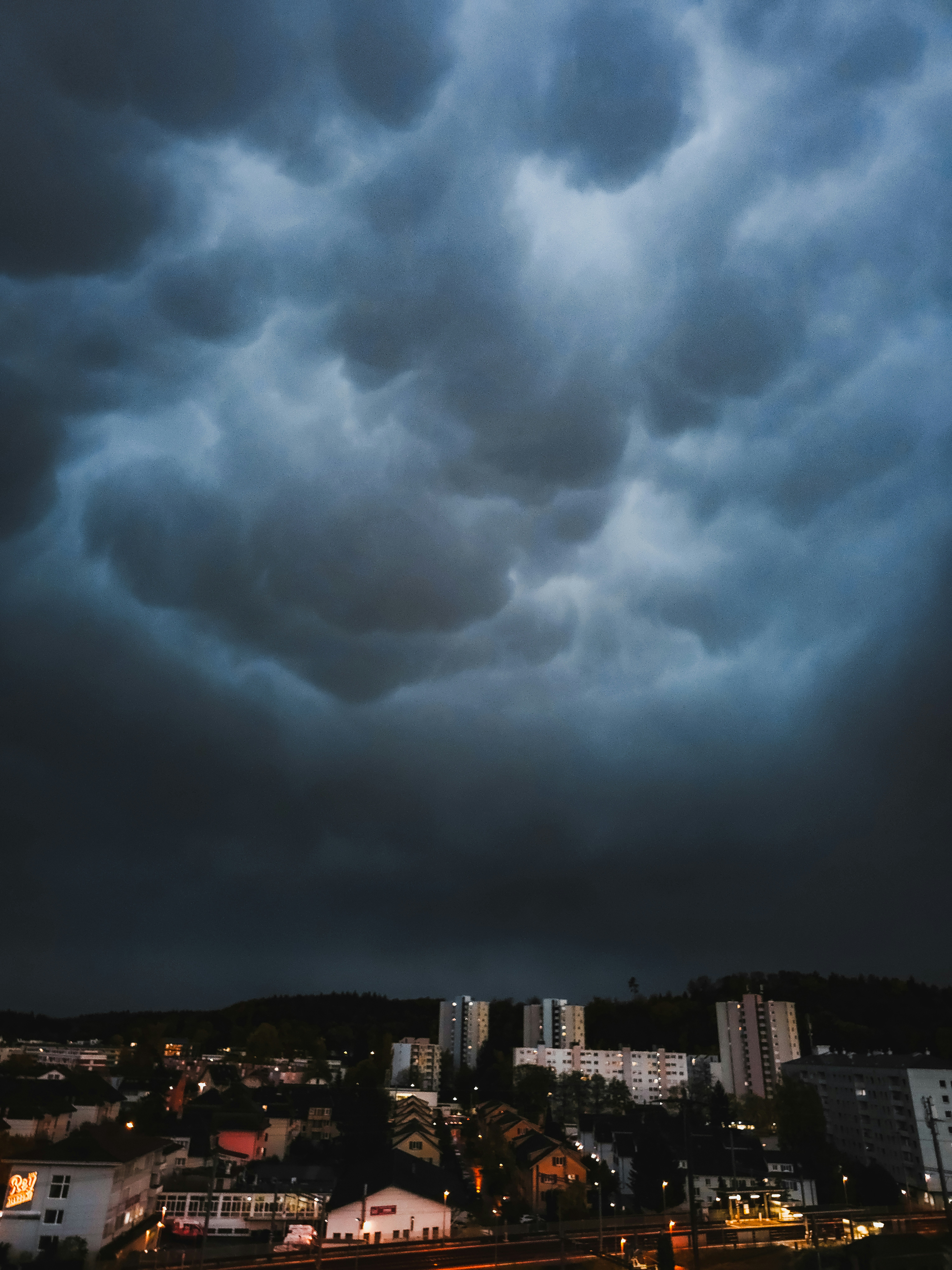 A very cloudy sky with some buildings in the background photo – Free ...
