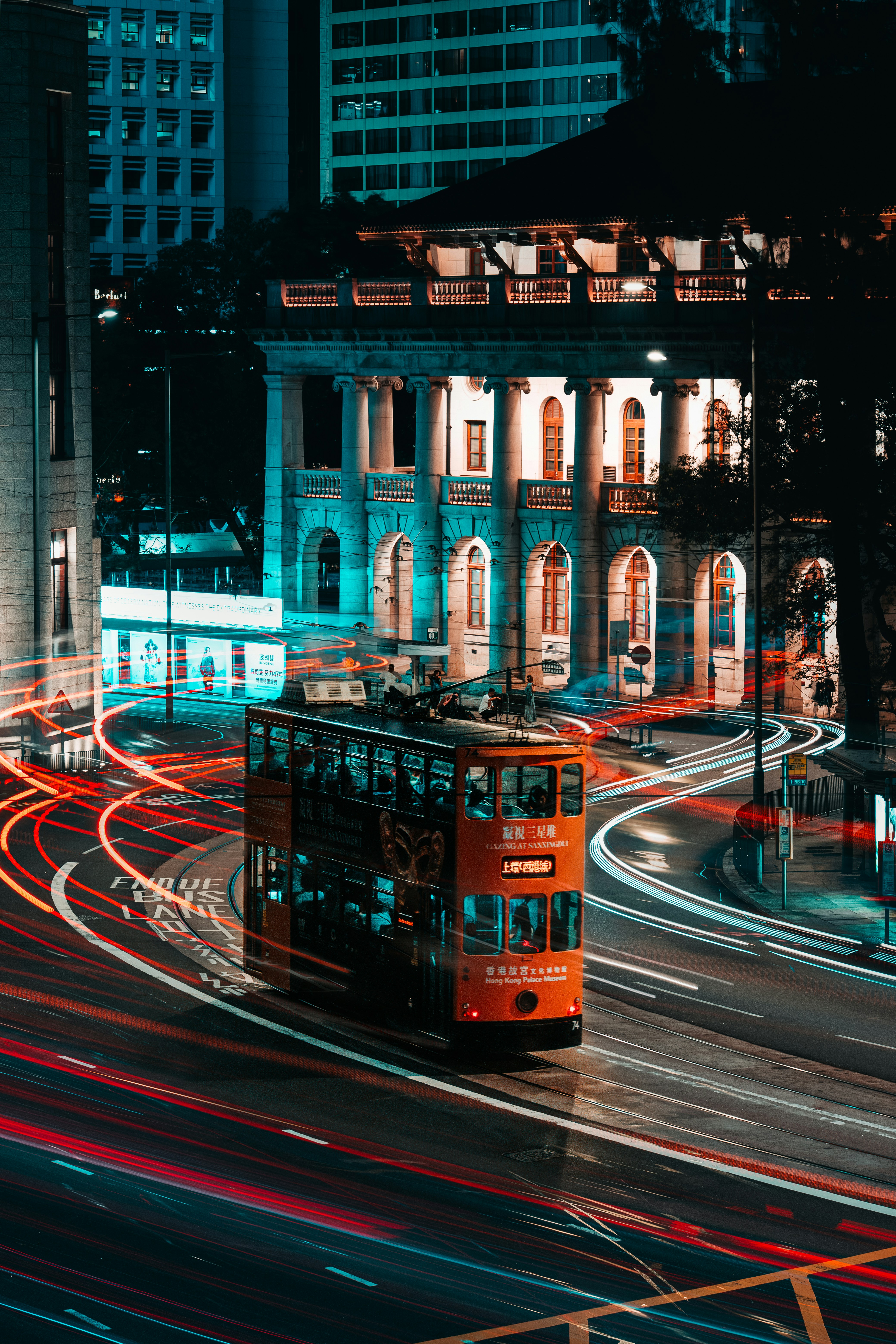 A double decker bus driving down a city street photo – Free Street ...