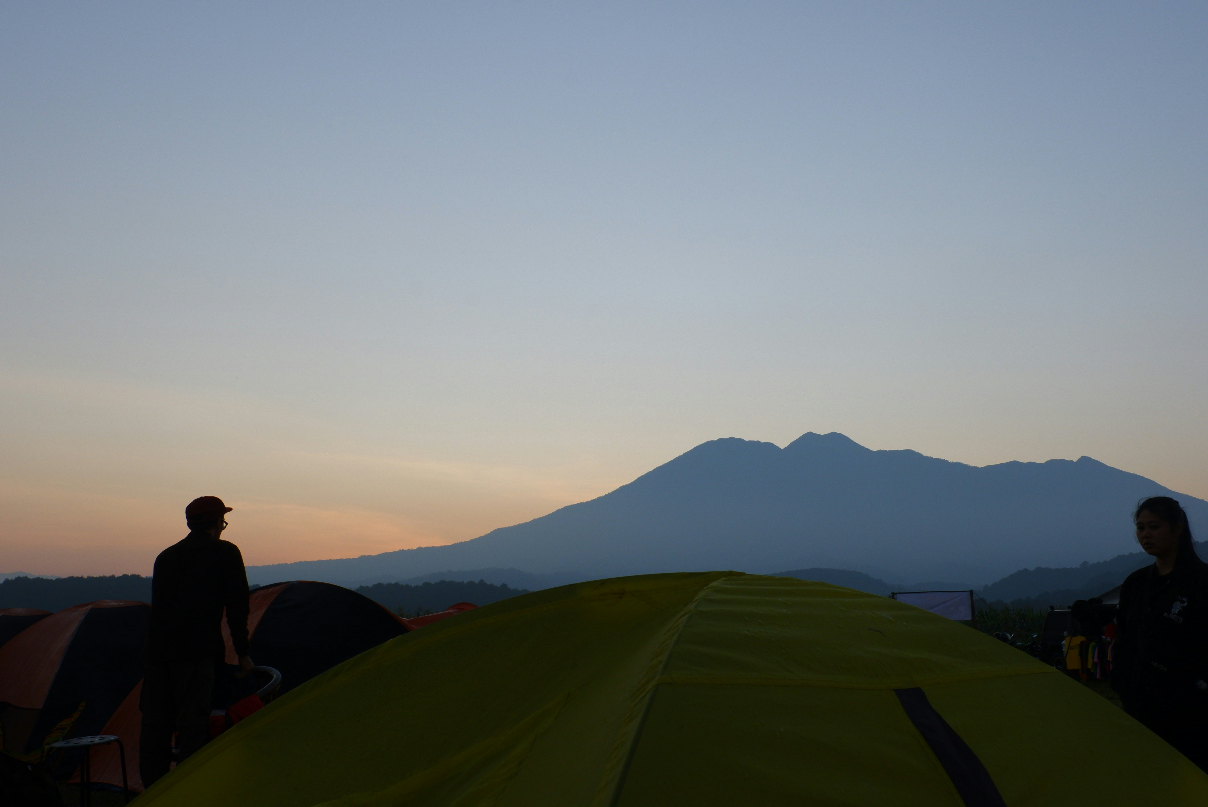 Dawn in the Camp: Tents and Shadowed Peaks