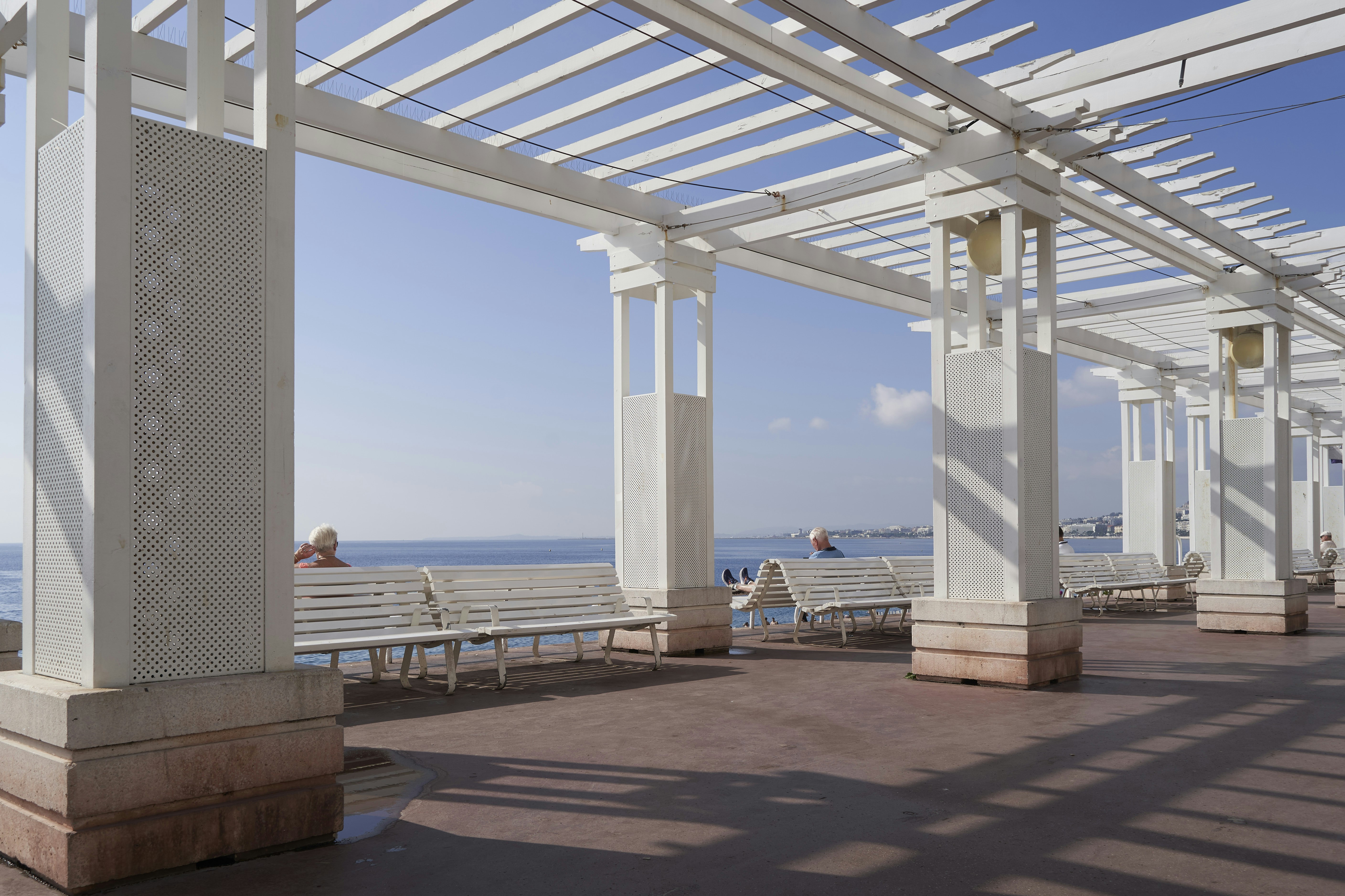 People sit on benches and look at the sea