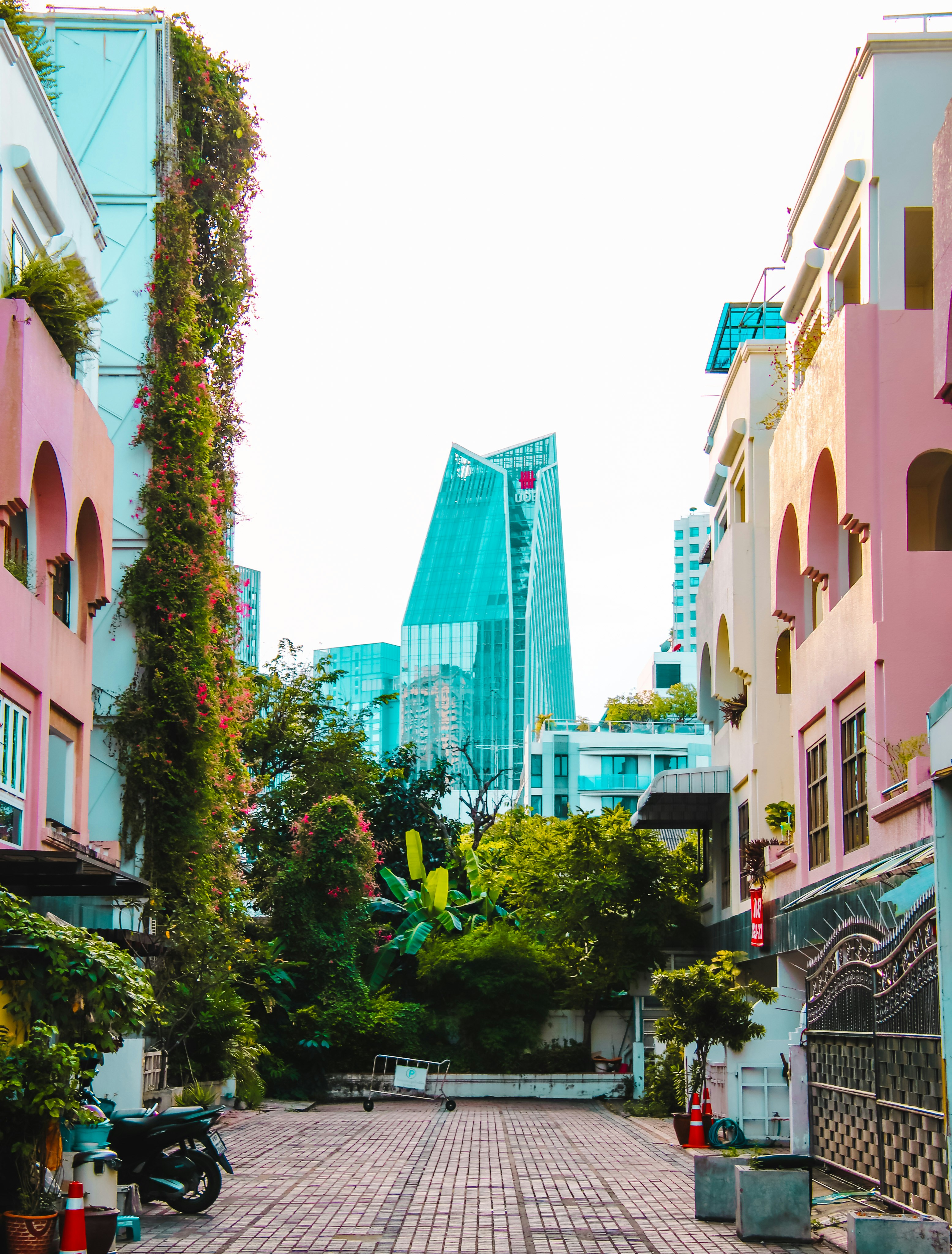 Pastel Alleyway Framing a Skyward Glass Frontier