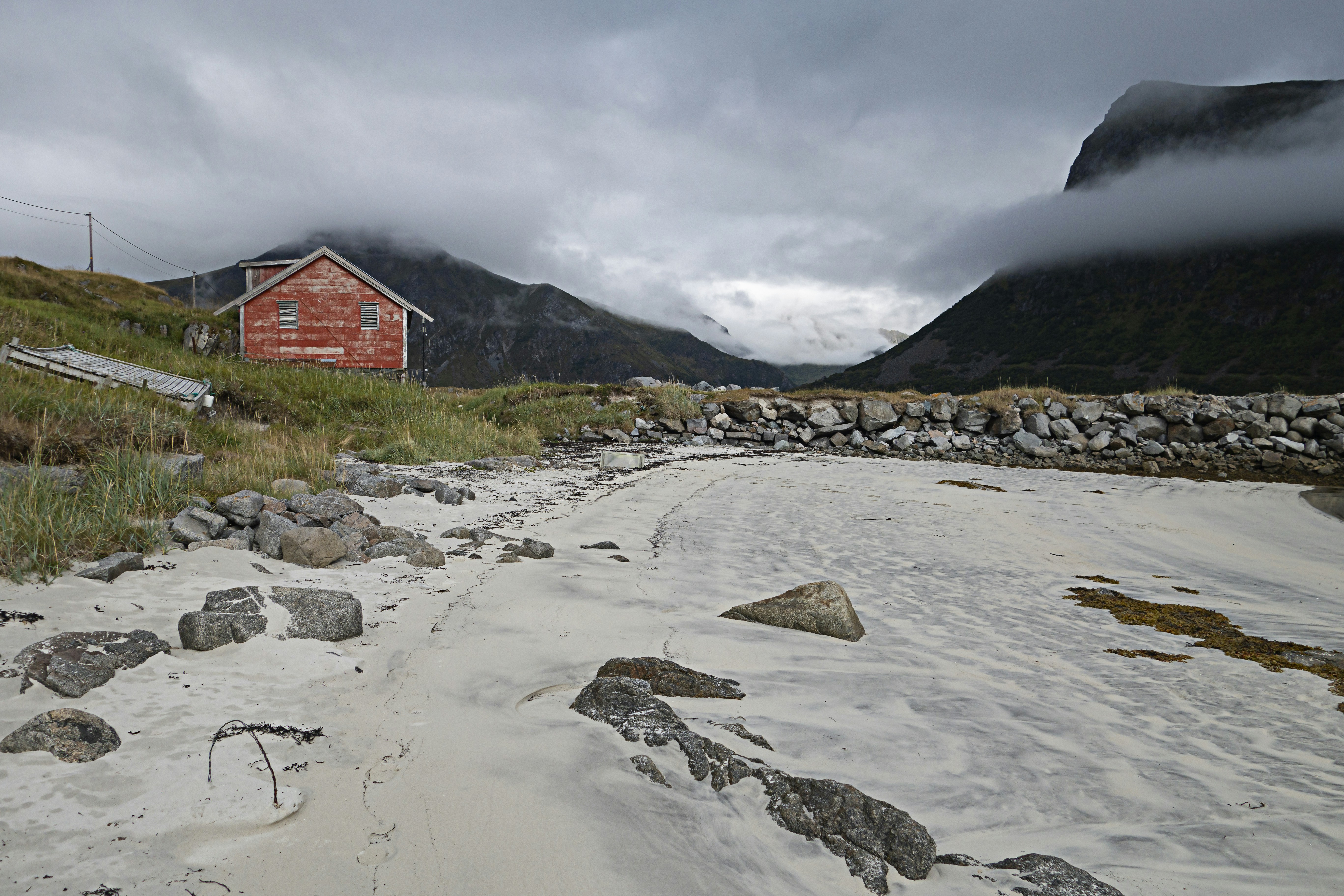 Red Cabin at the Margin of a Mist-Wrapped Mountain Shore