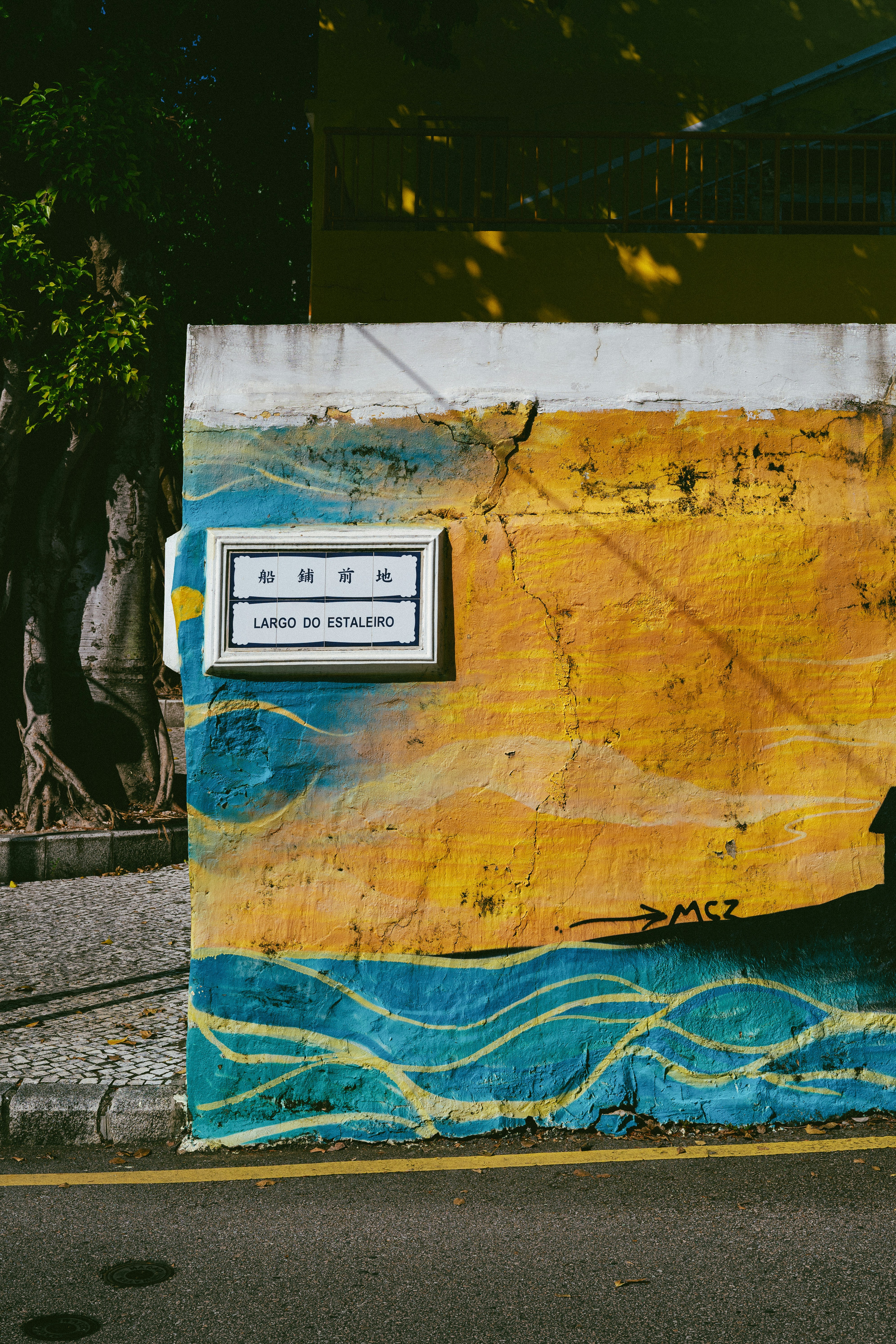 Sunlit mural and sign at Largo do Estaleiro
