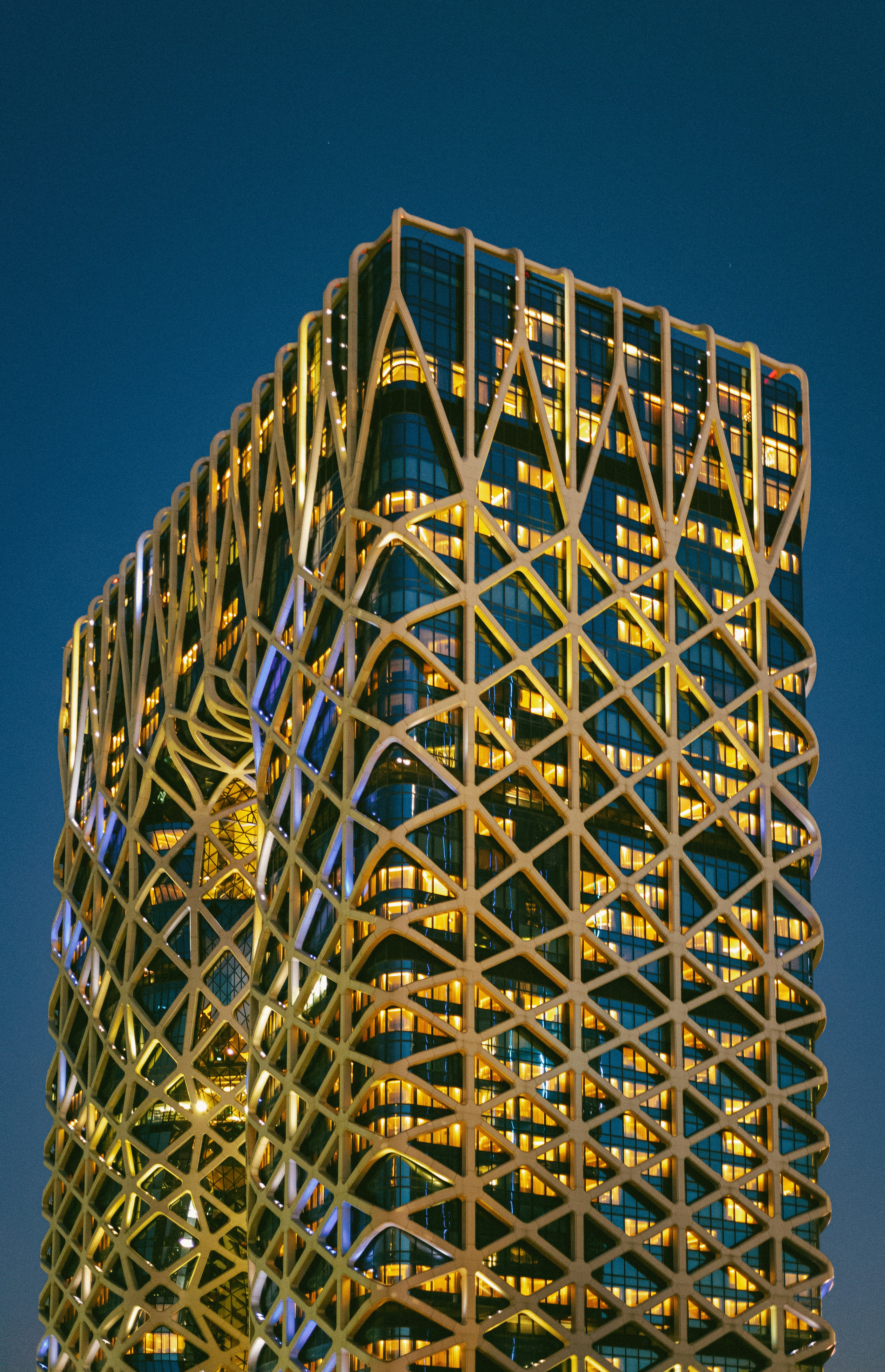 Crisscrossed Night: Lattice Skyscraper Illuminated Against a Velvet Sky