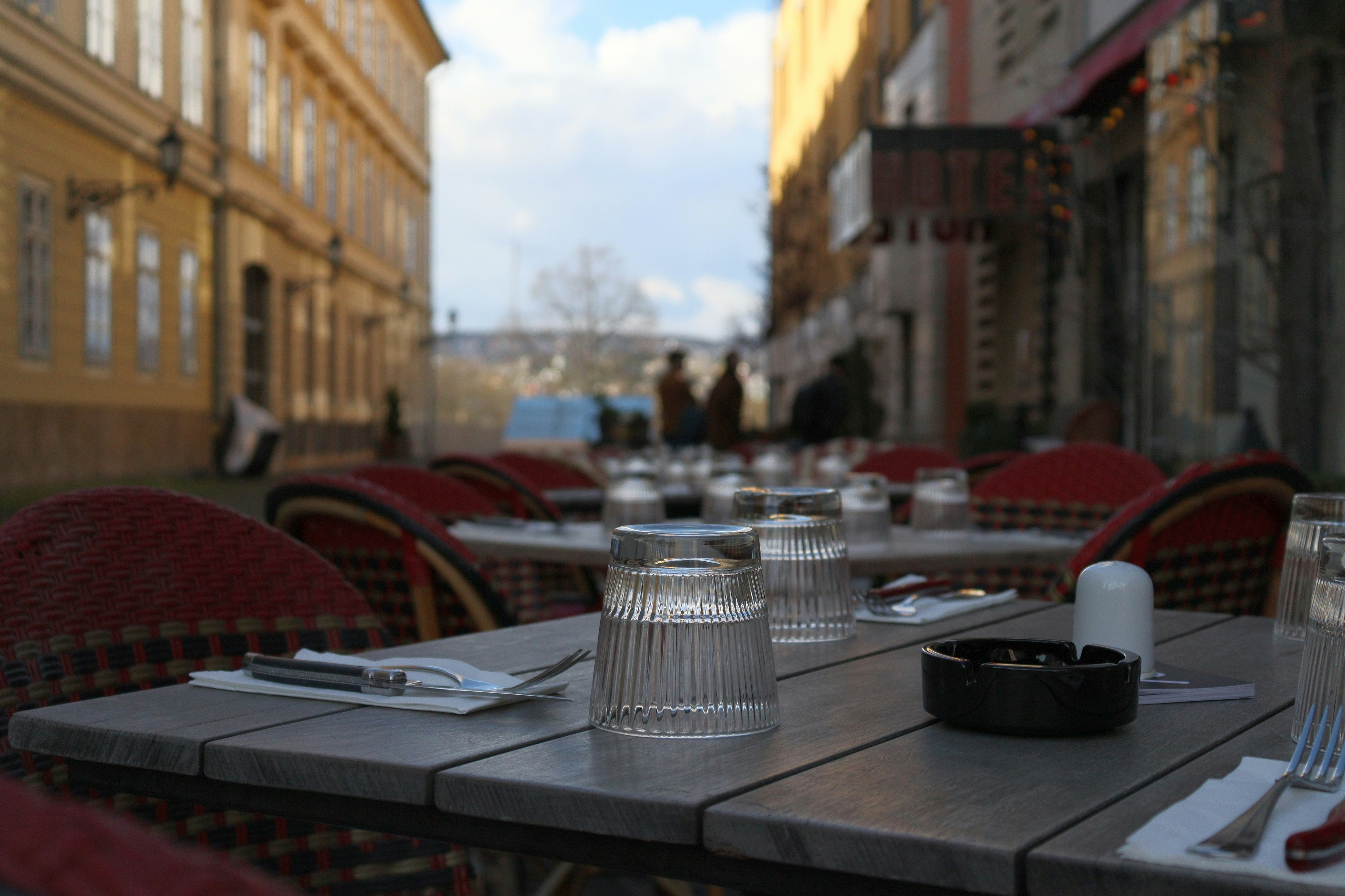 Center-Table Glasses Framing a Sunlit Street Café in Soft Focus