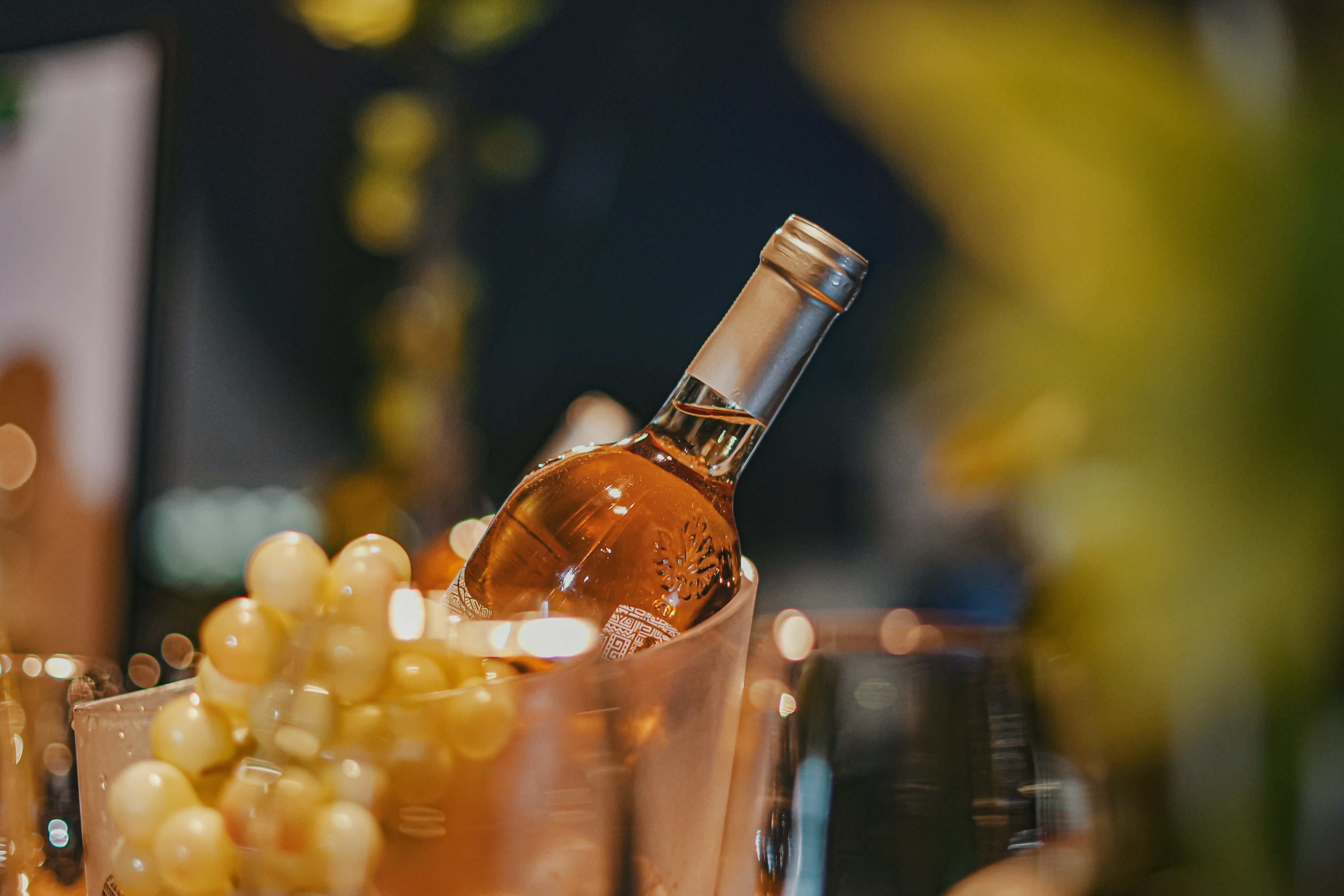 Chilled Elegance: A Bottle Amidst Grapes