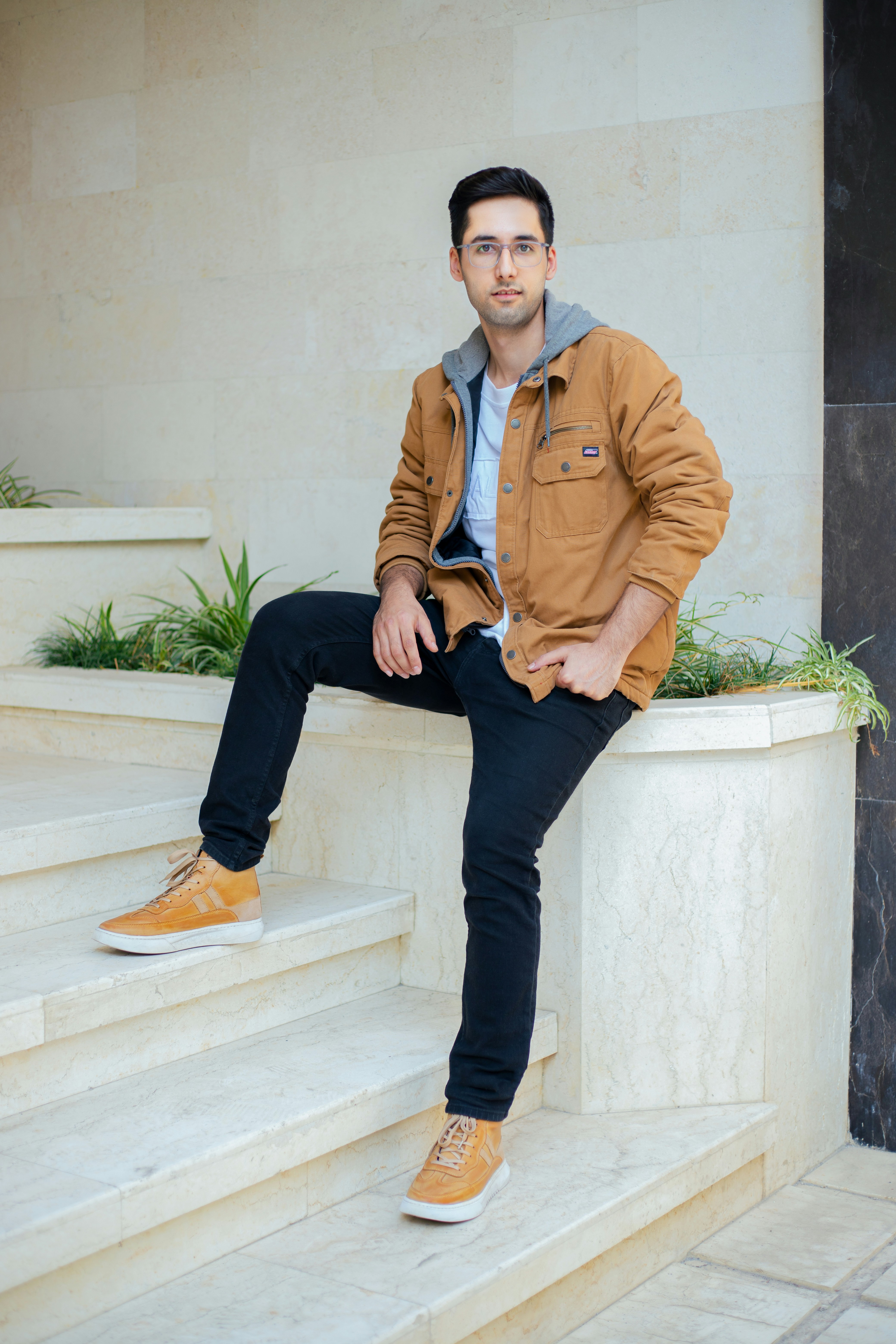 A man sitting on a set of stairs photo – Free Jacket Image on Unsplash