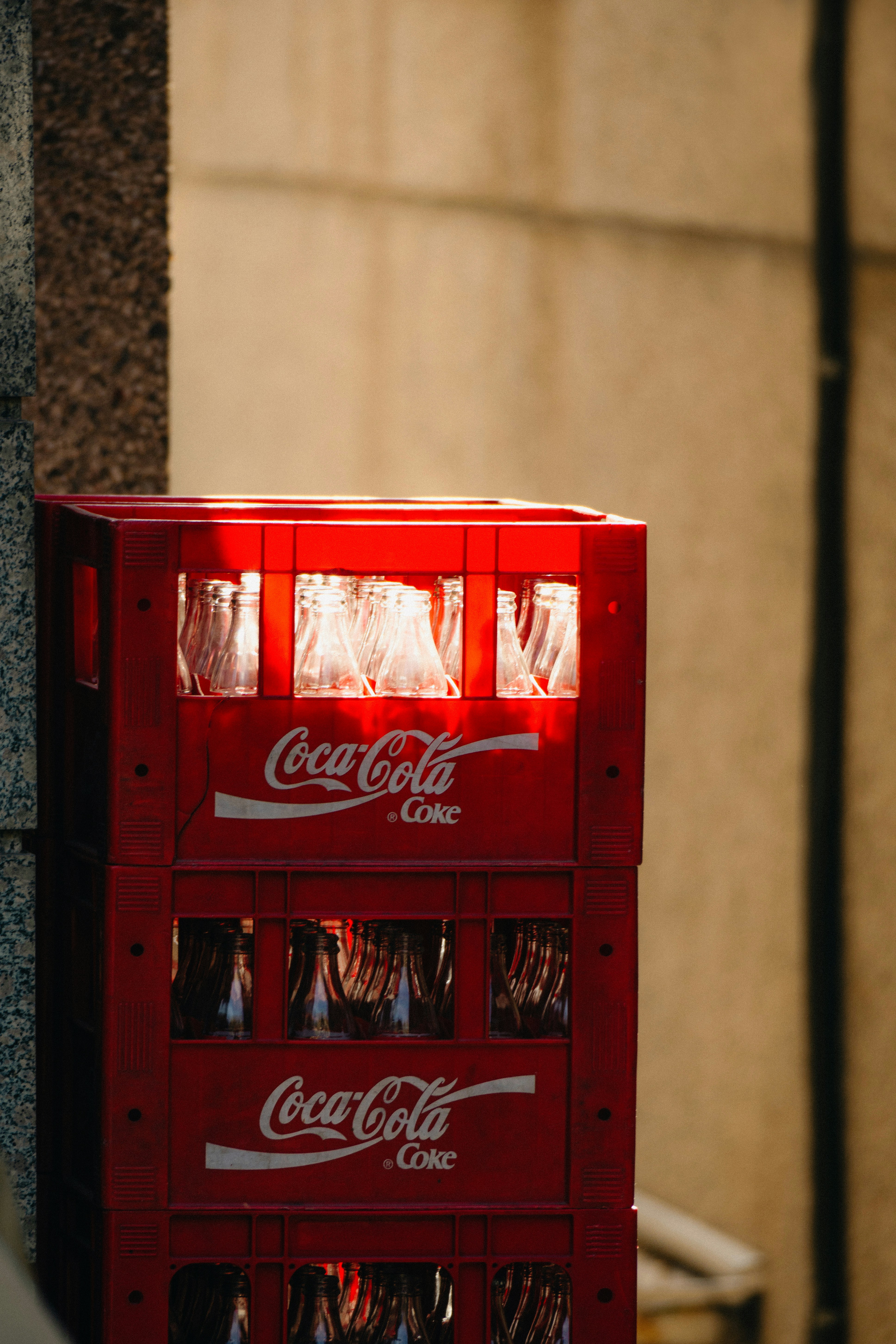 A red coca - cola machine sitting on the side of a building photo ...