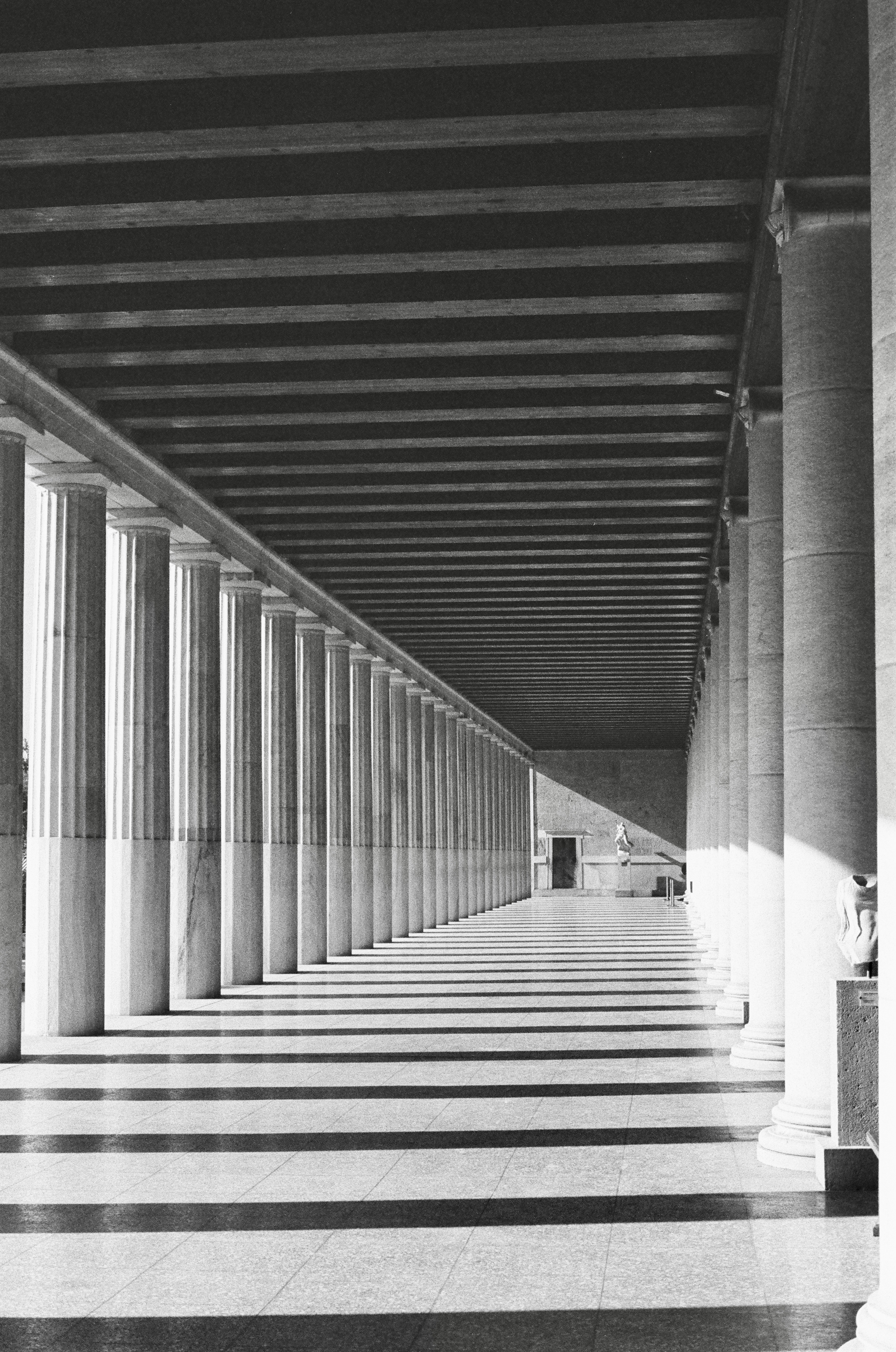 a black and white photo of columns in a buildingVASSILIOS SKENTZOS