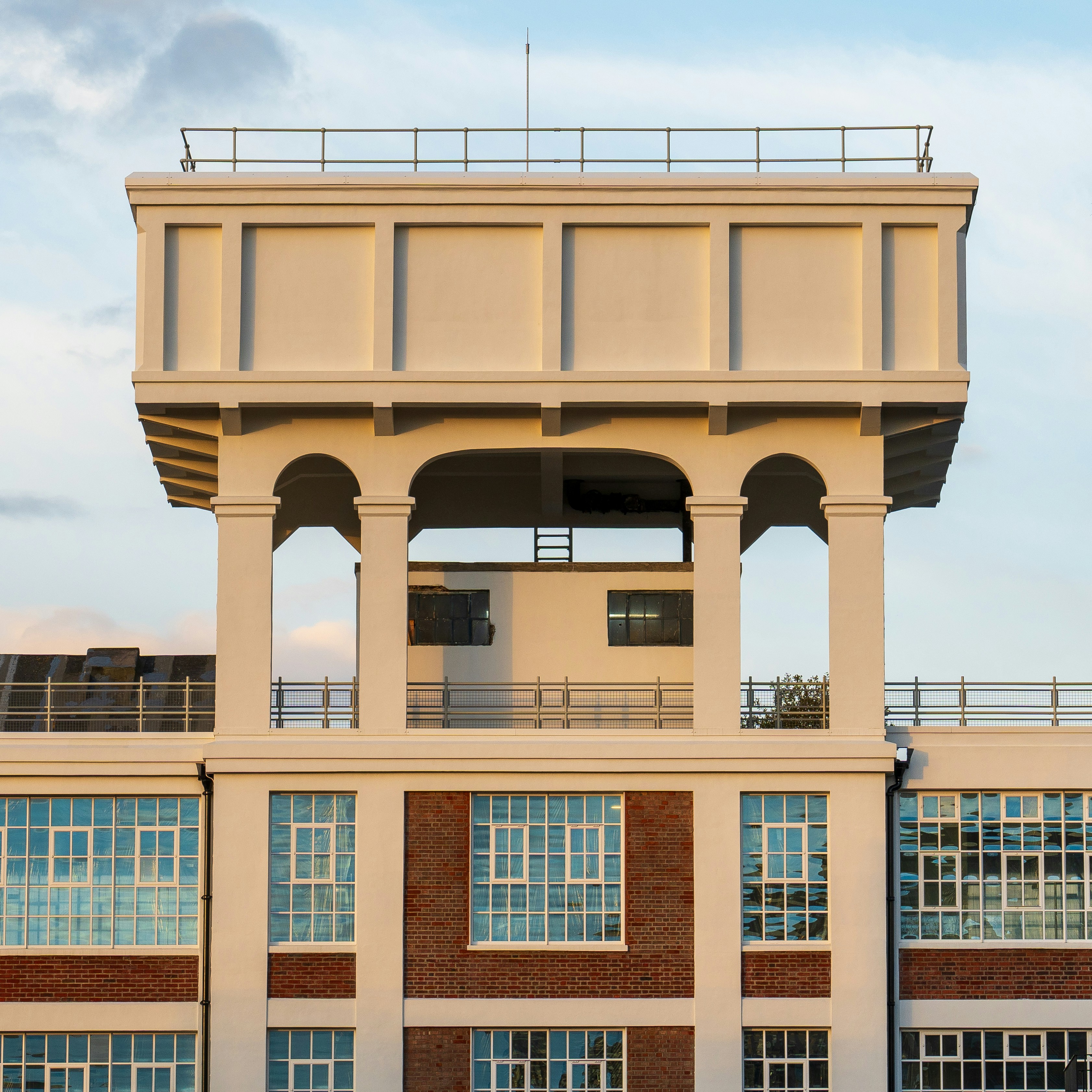 Crowning Arches: Sunlit Tower Over a Brick Wing