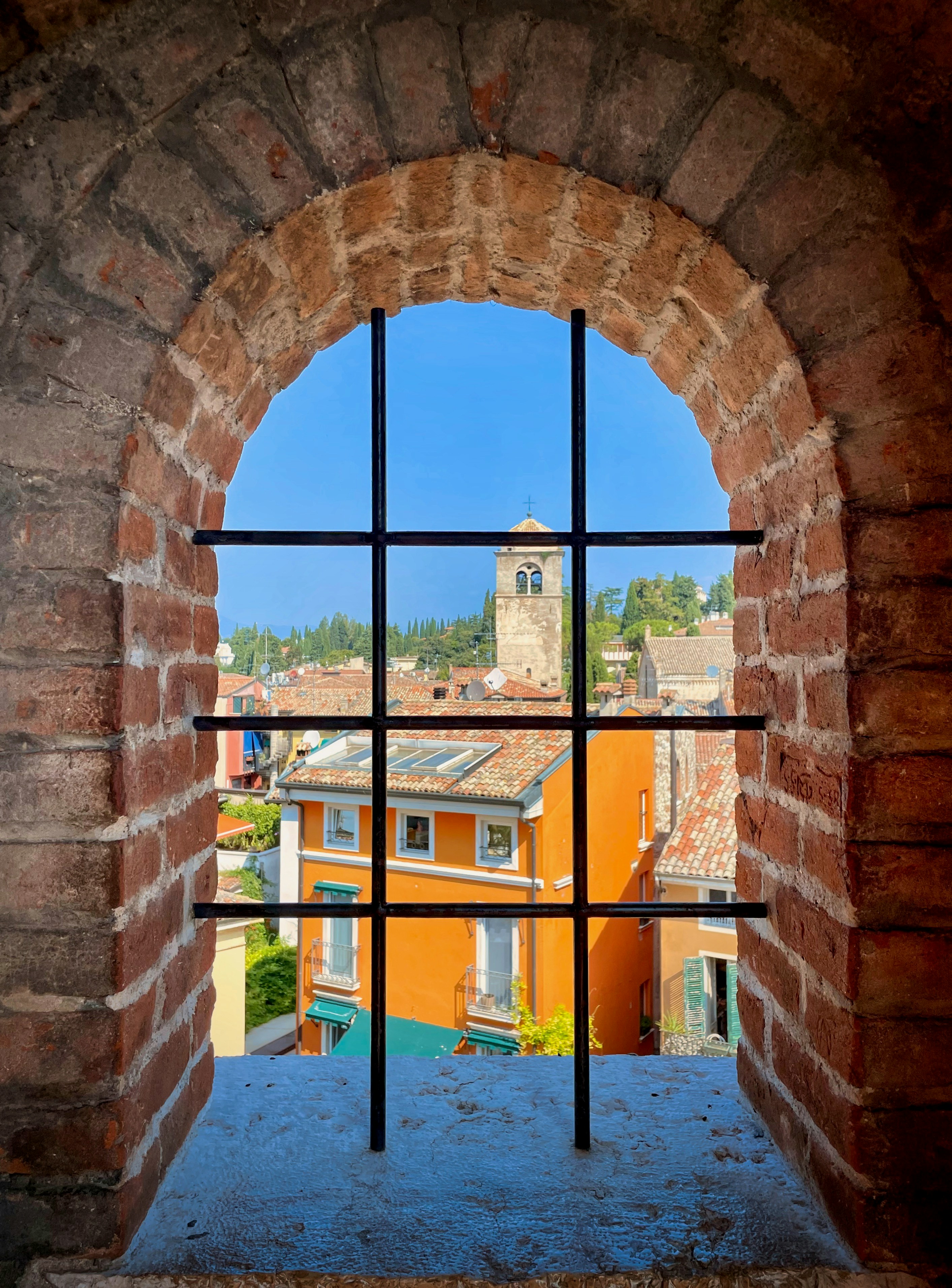 A window with a view of a city through it photo – Free Blue Image on ...