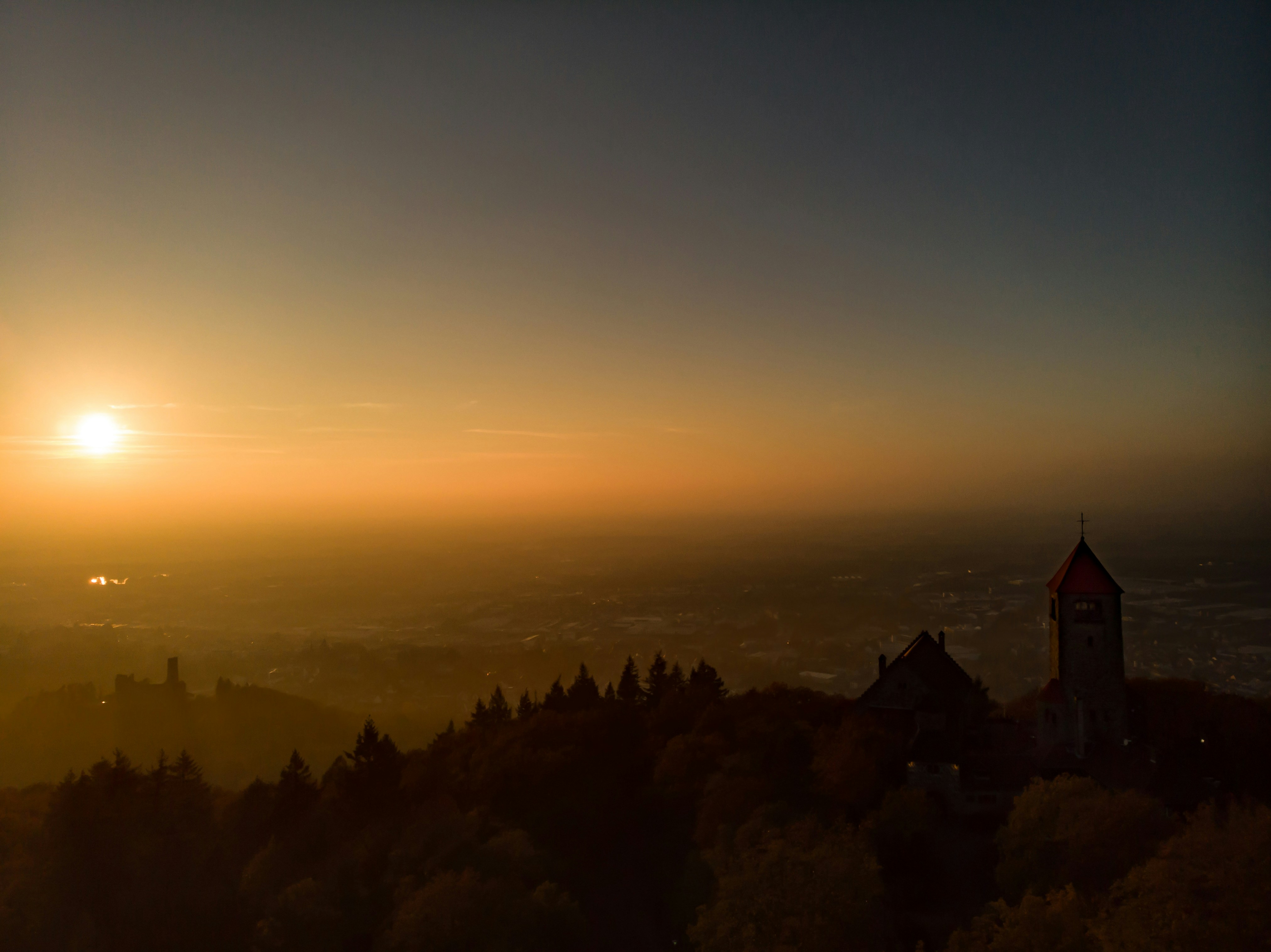 The sun is setting over a hill with a tower photo – Free Forest Image ...