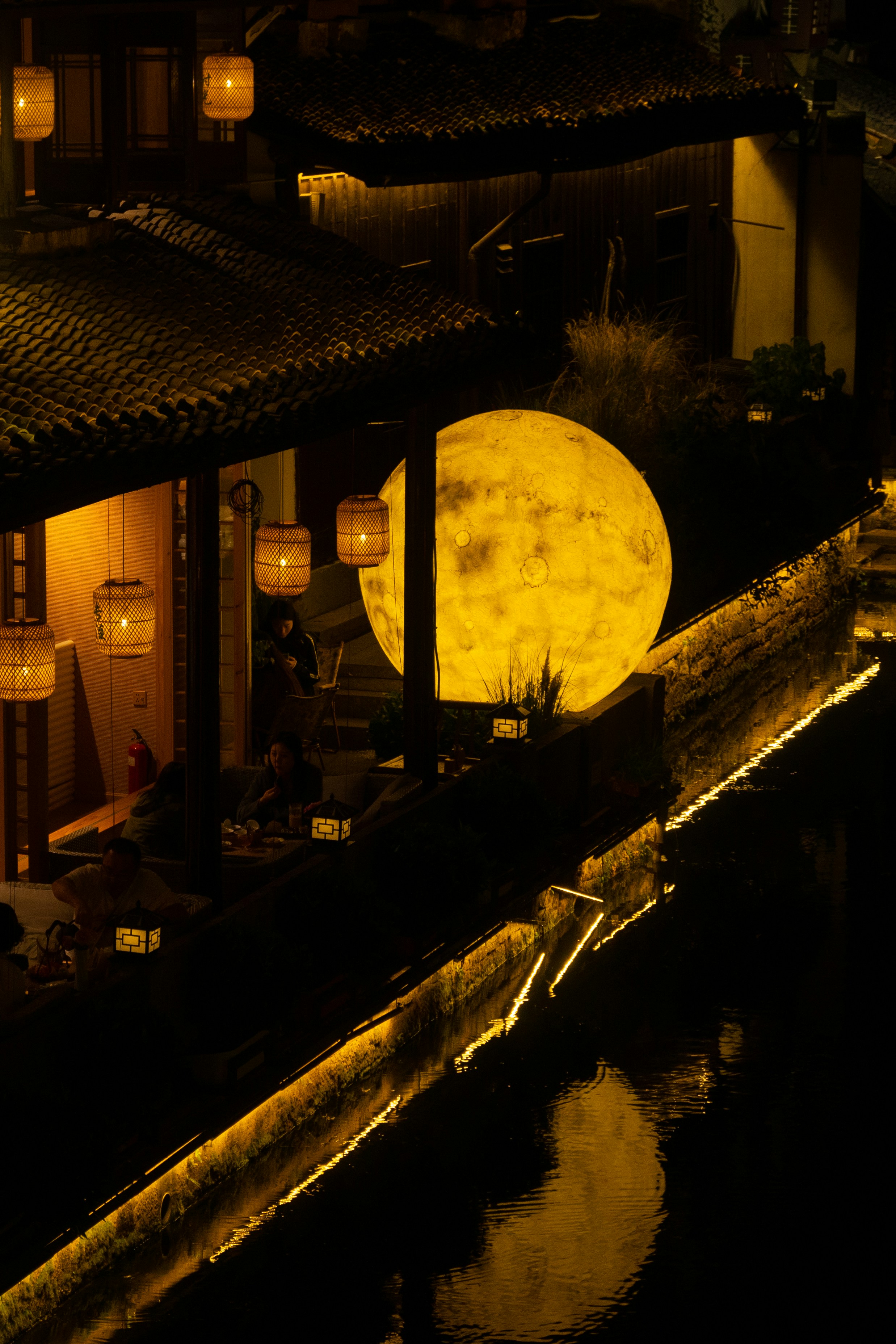Amber Orb Over the Canal: Lantern-lit Dining at Night