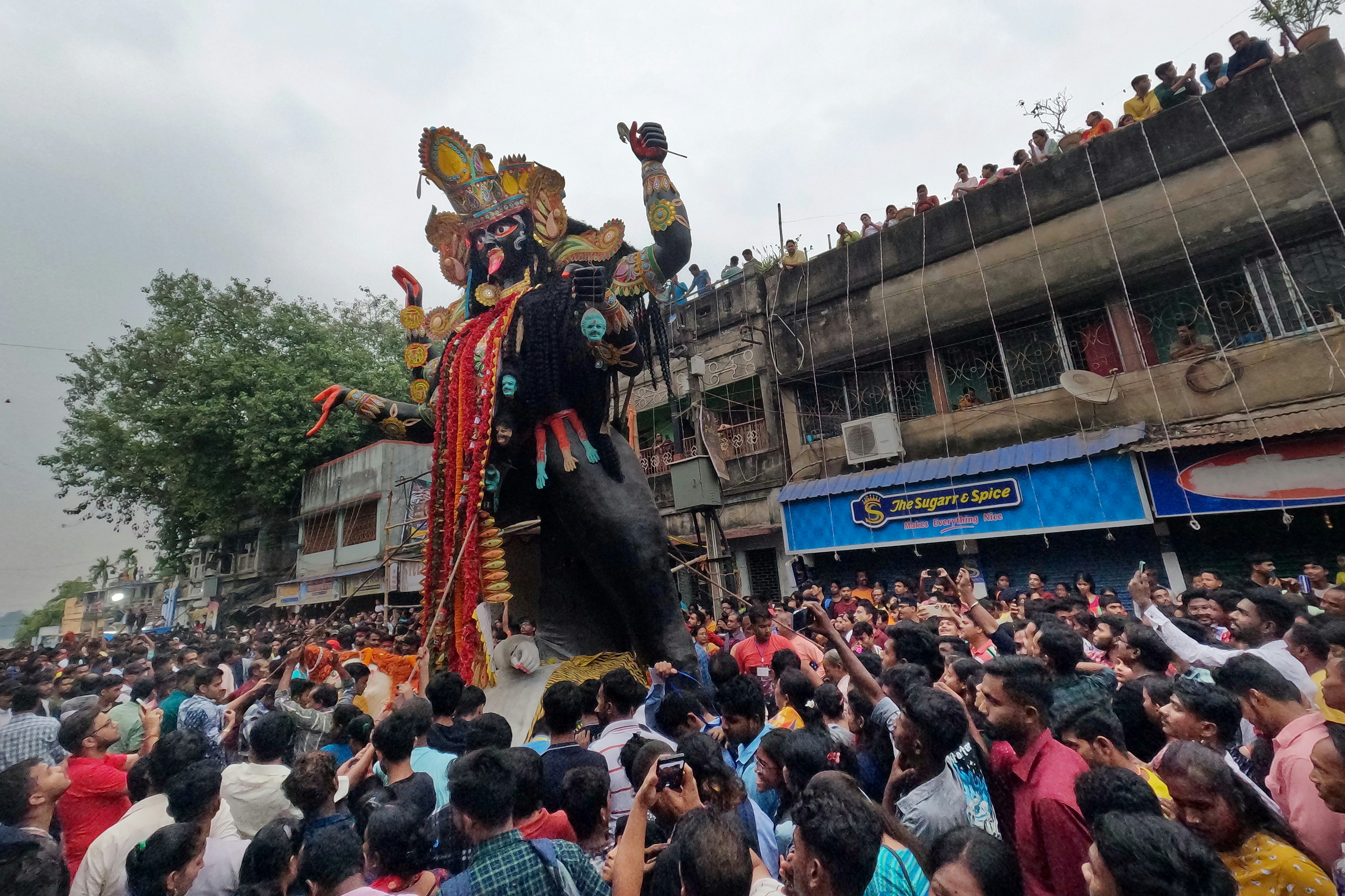 Colossal Deity Float Surges Through a Crowded Street Festival