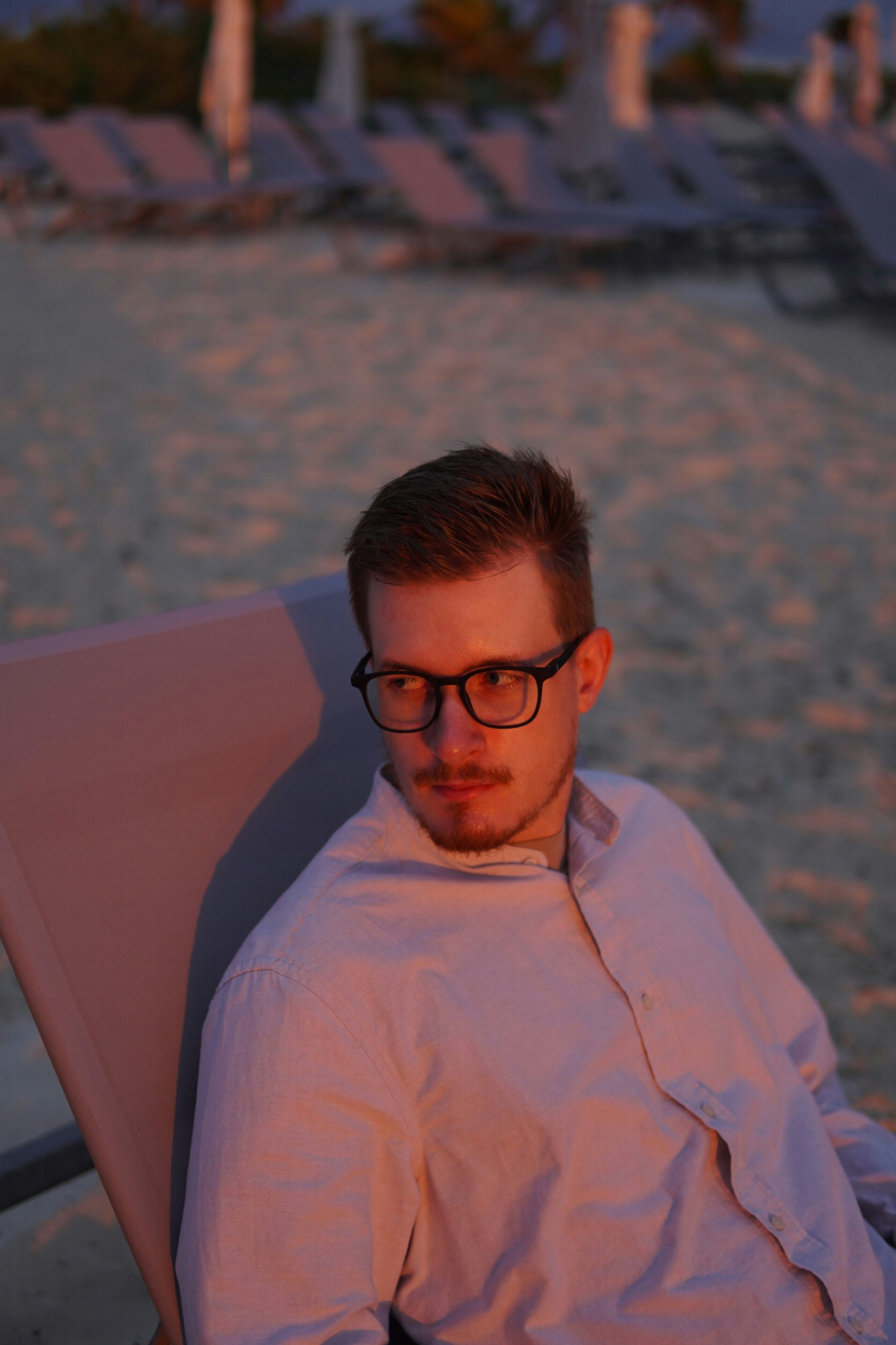 浜辺の椅子に座る男の写真 – Unsplashの壁紙の無料画像