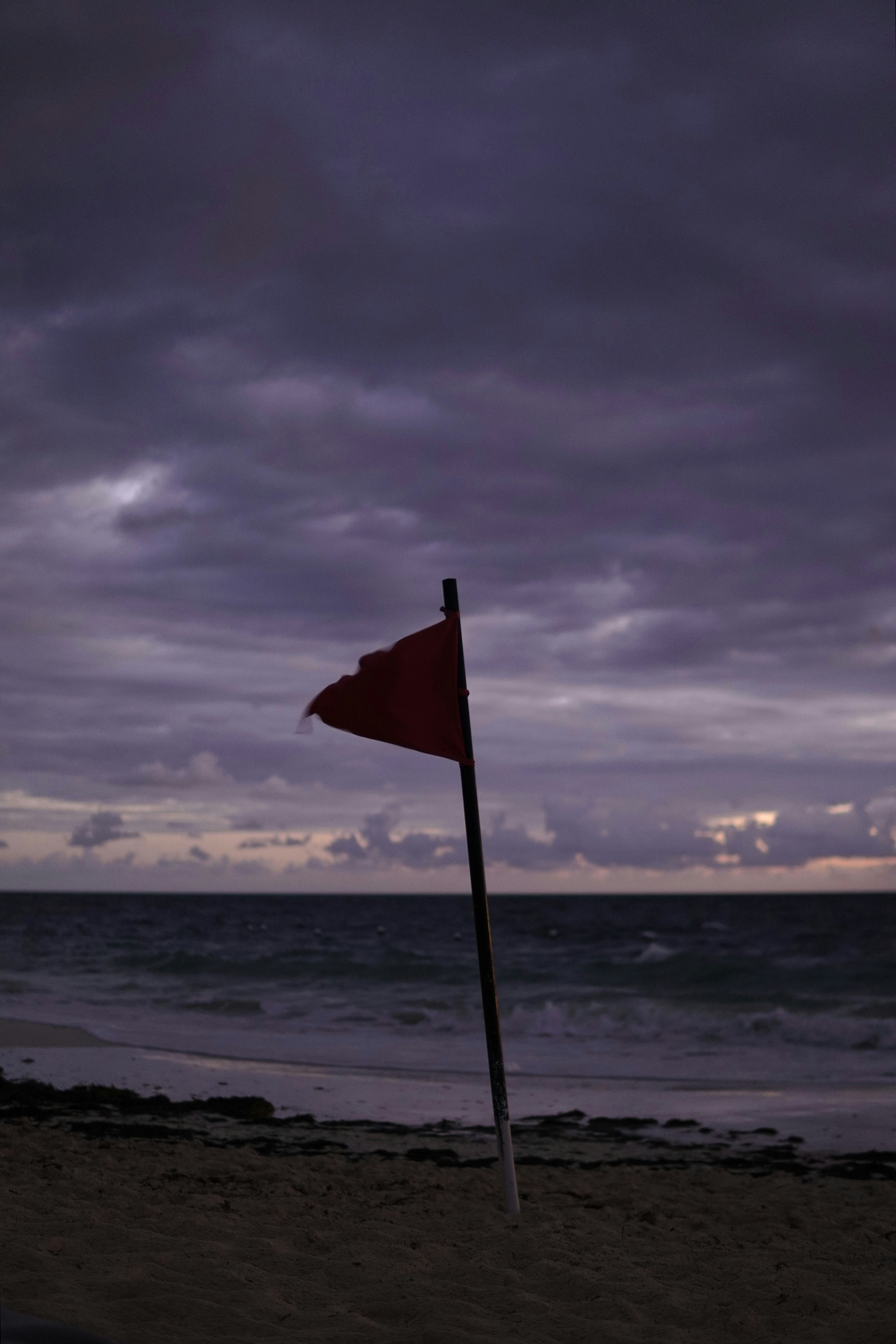 A red flag on a pole on a beach photo – Free Mexico Image on Unsplash