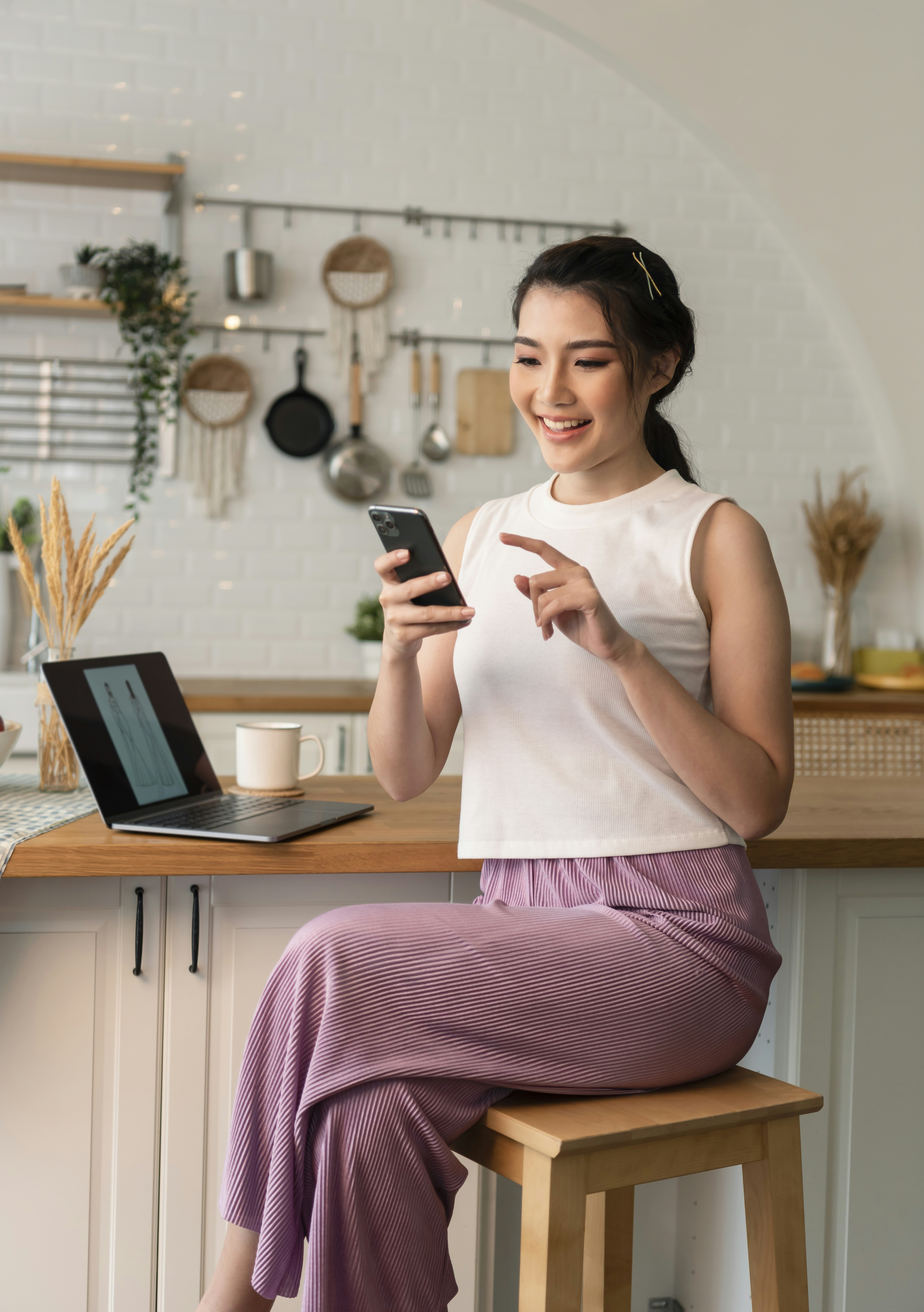A woman sitting on a stool using a cell phone photo – Free Human Image ...