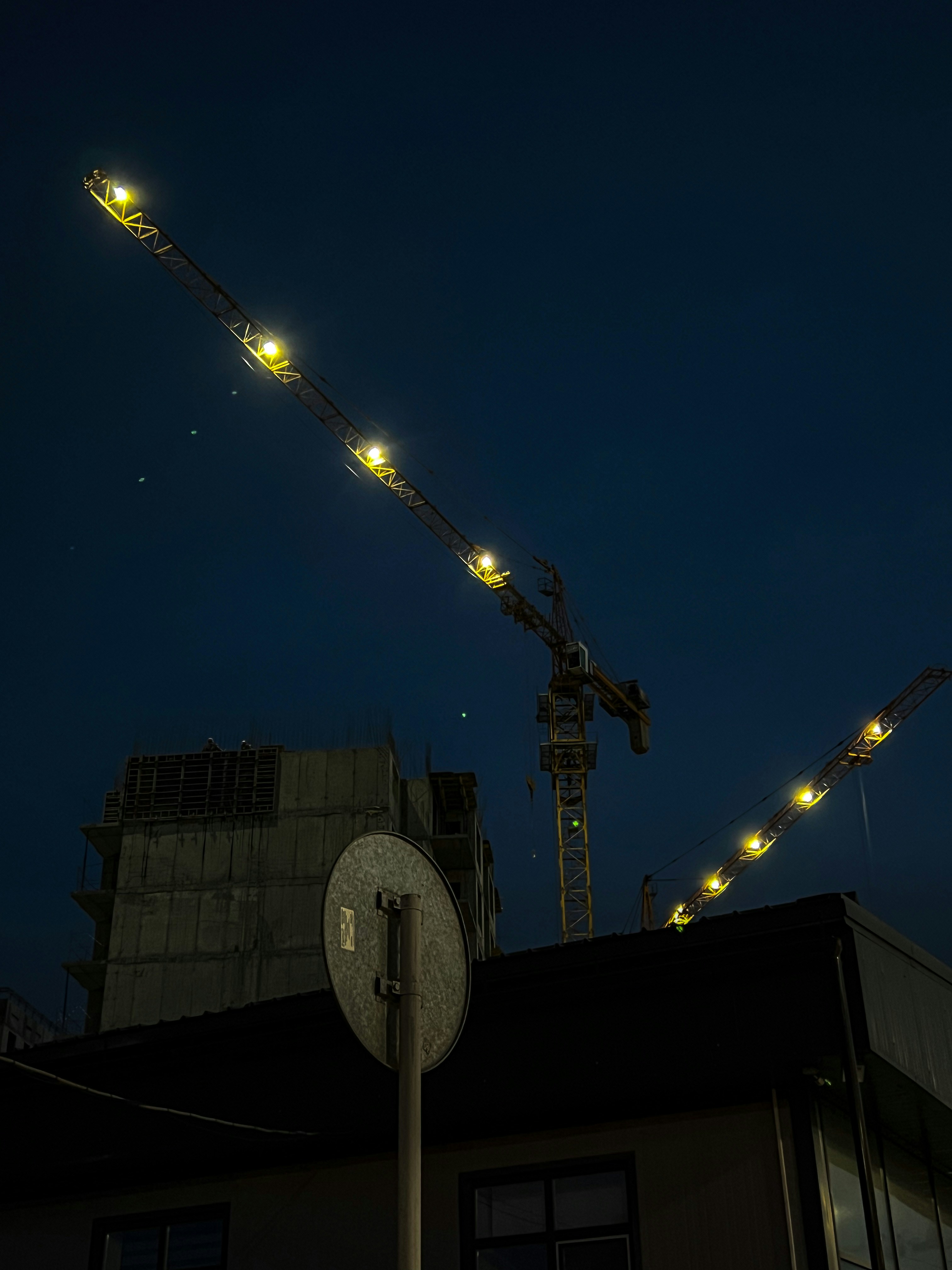 Moonlit Cranes Over the Quiet City: A Night Construction Scene
