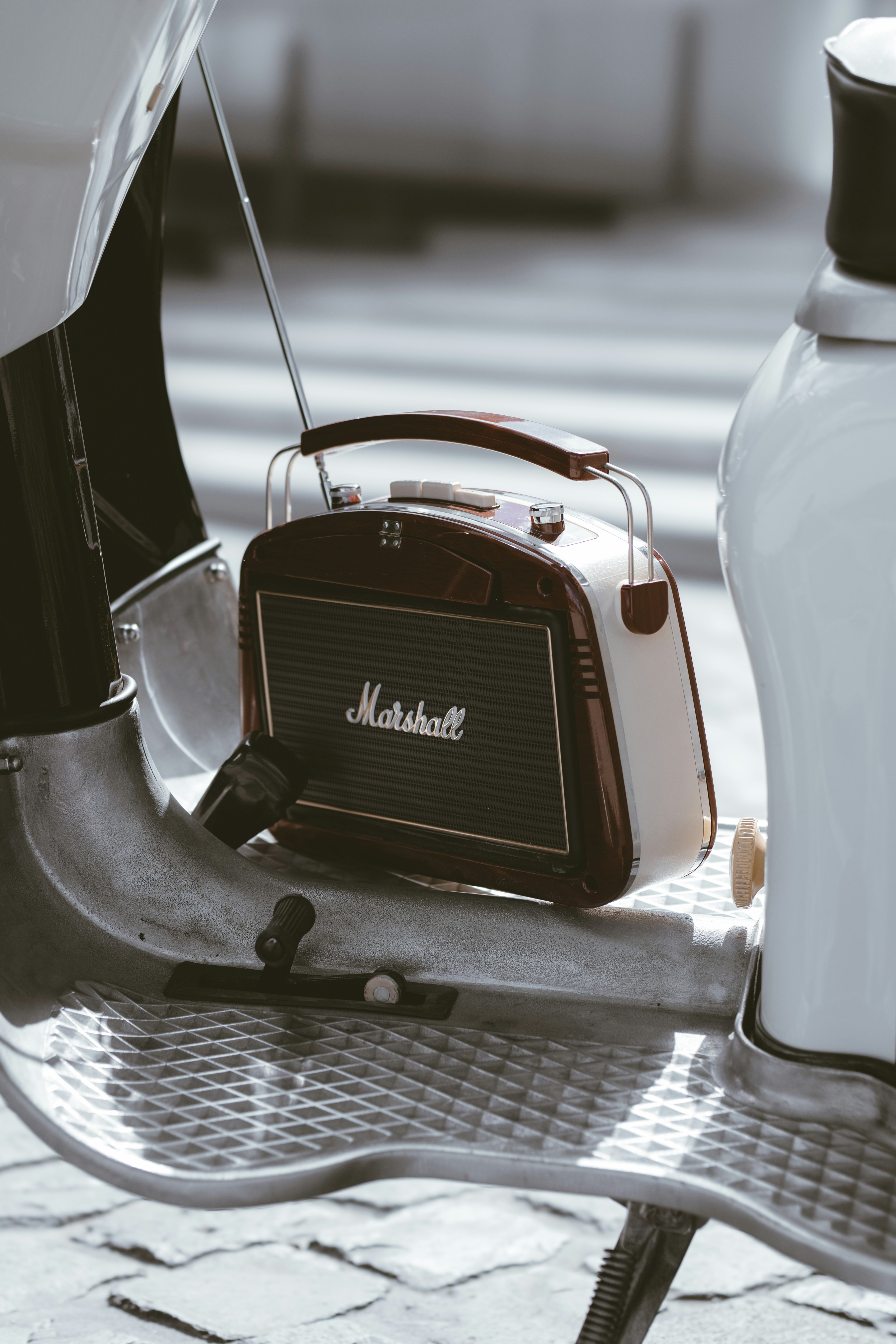 A vintage Marshall speaker nestled beside a classic scooter, showcasing a blend of retro design and modern style.