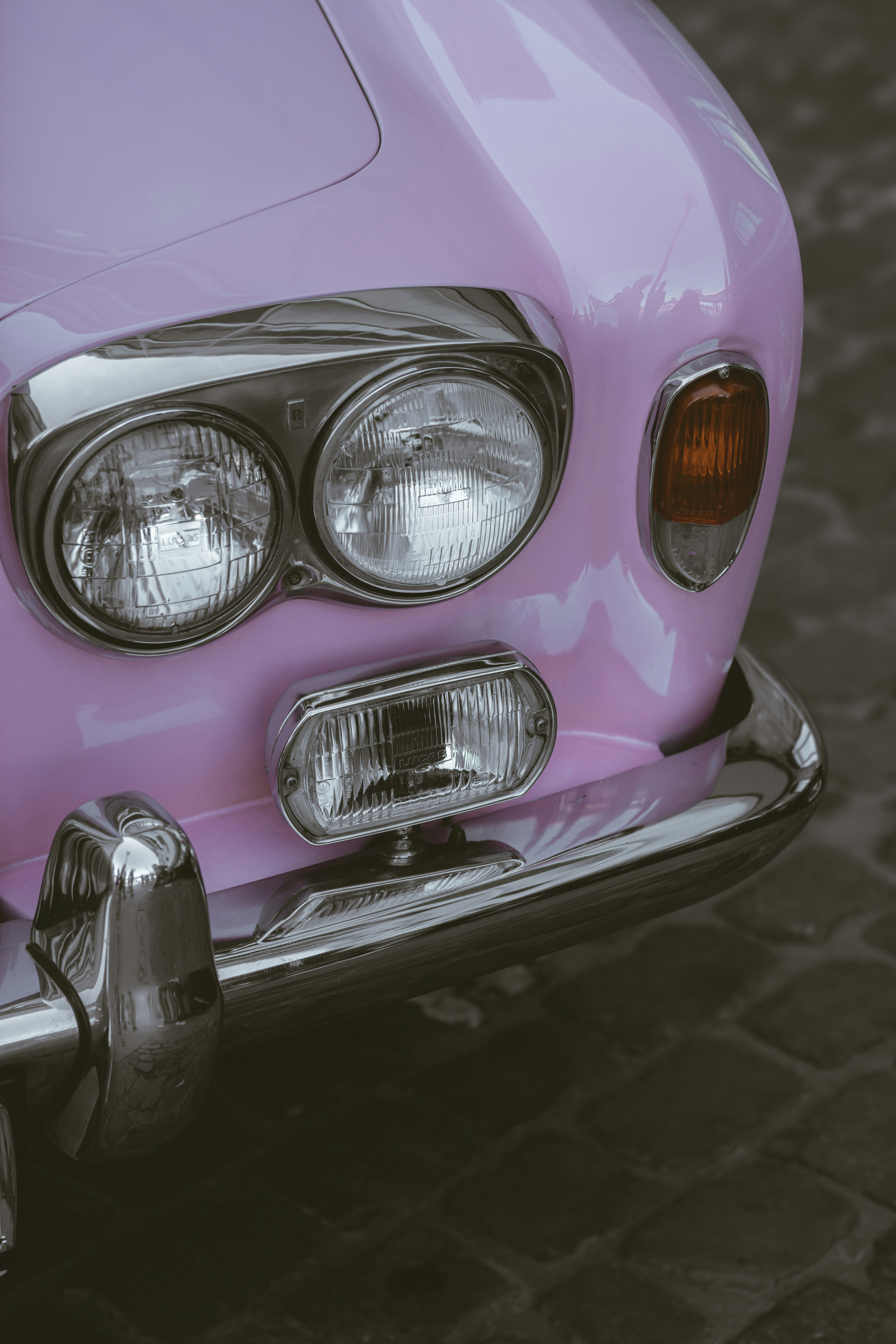 Pastel Lilac Front: close-up of a vintage car's twin headlights and chrome bumper