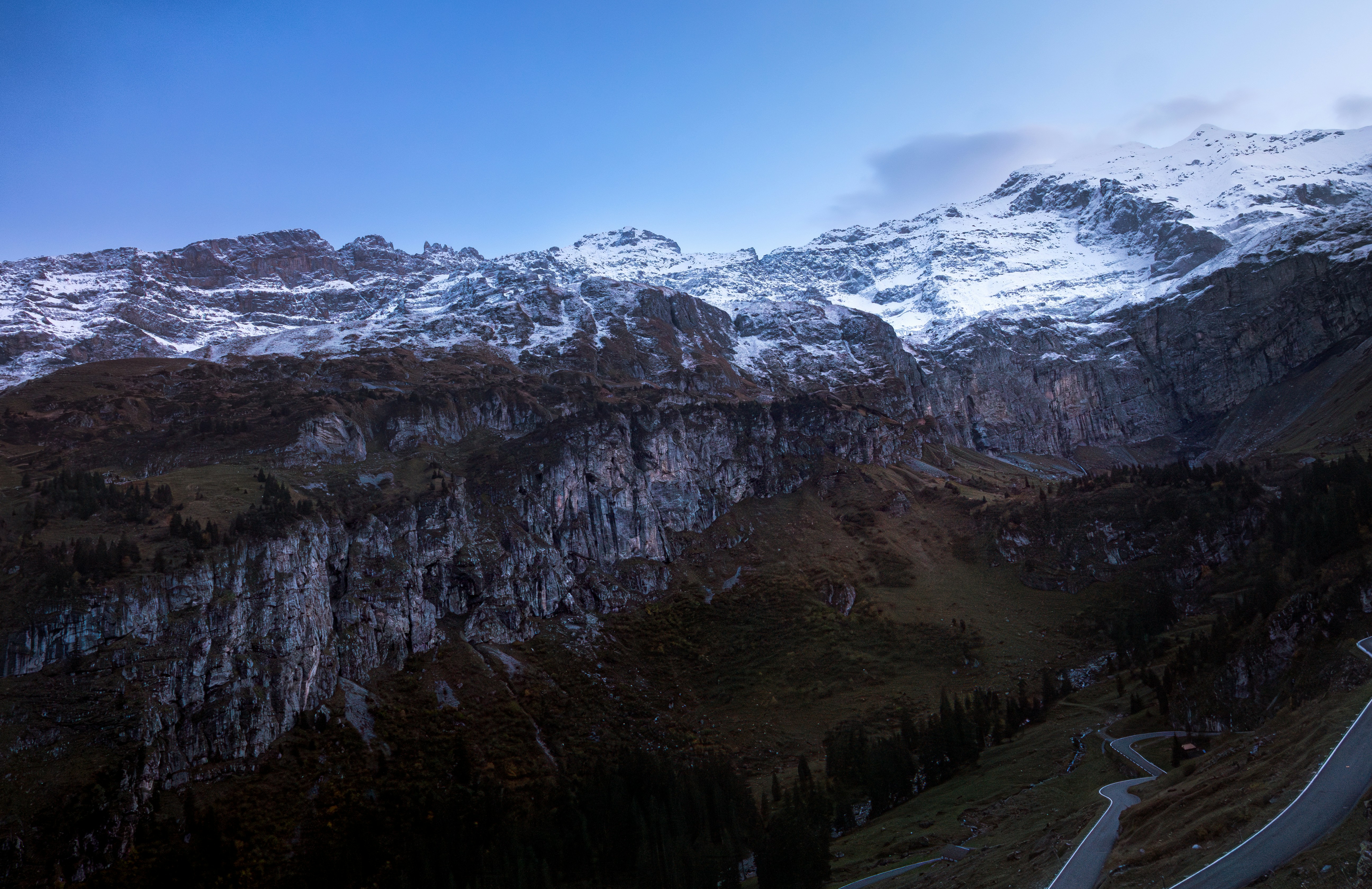Blue Hour Ridge: Snow-Kissed Peaks and a Winding Alpine Road