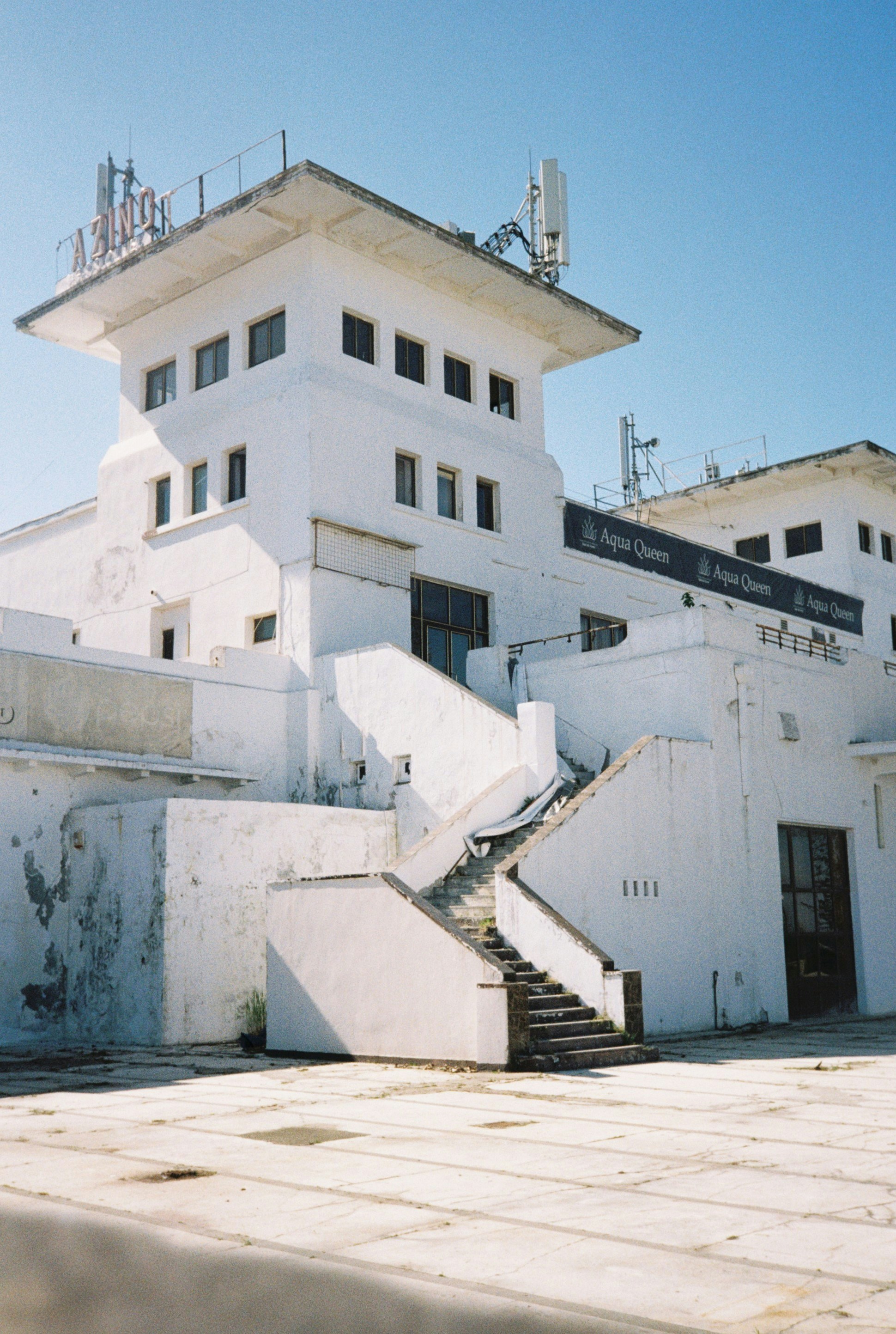 White architectural beacon: sunlit stairway ascending to a rooftop outpost