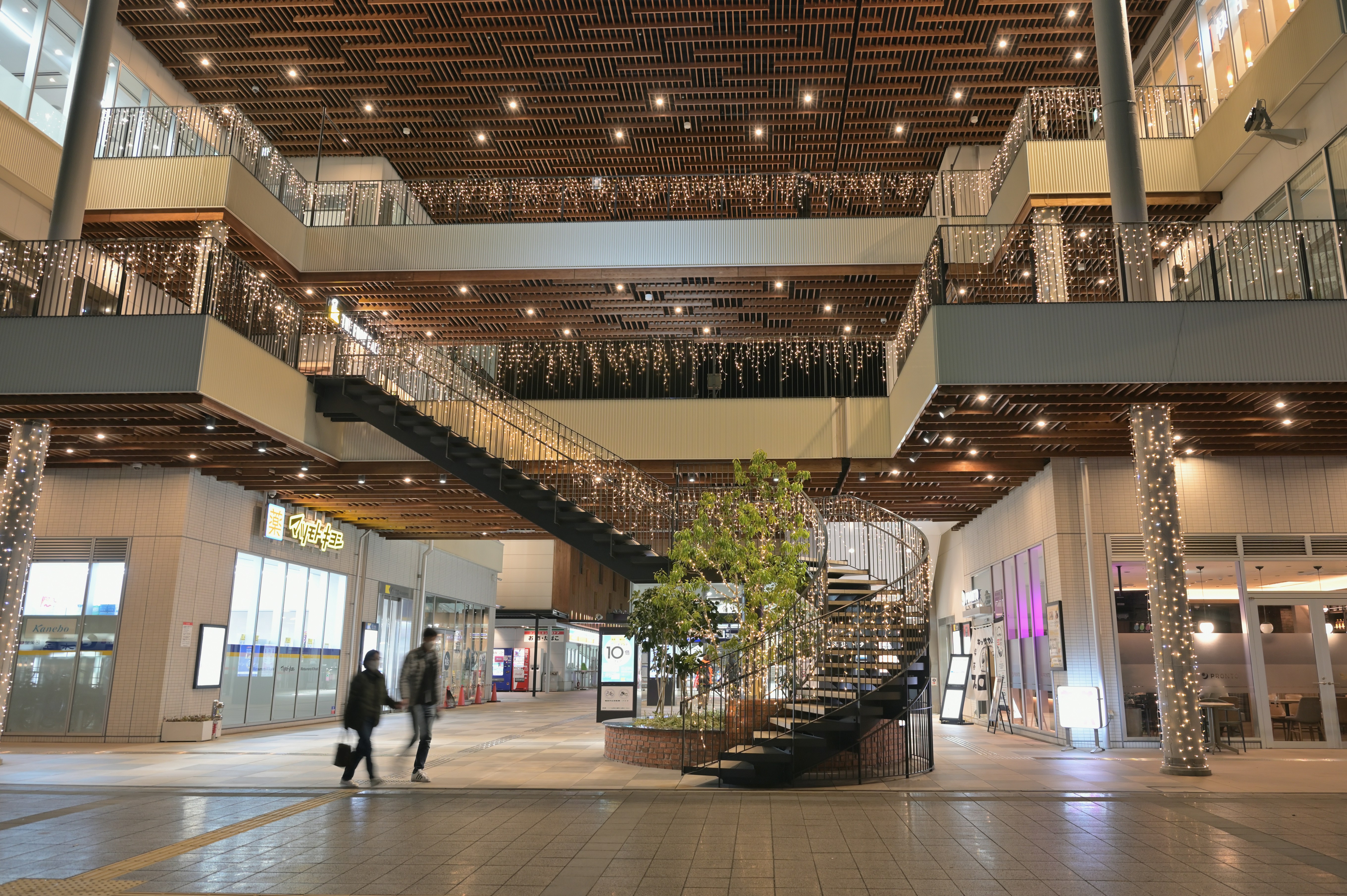 A couple of people walking inside of a building photo – Free 光 Image on ...