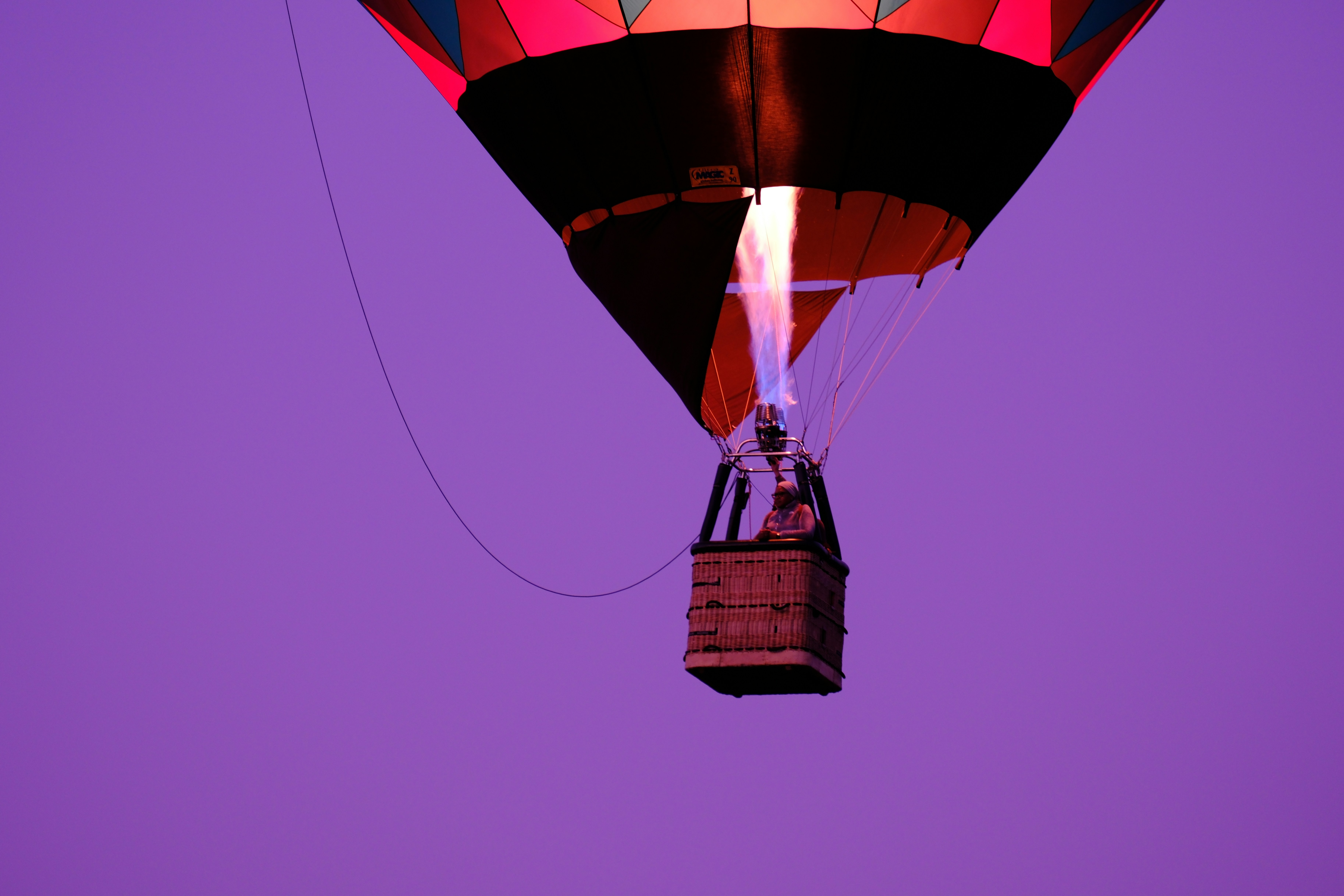 Fiery Breath Under a Violet Sky: A Balloon Basket's Upward Gaze