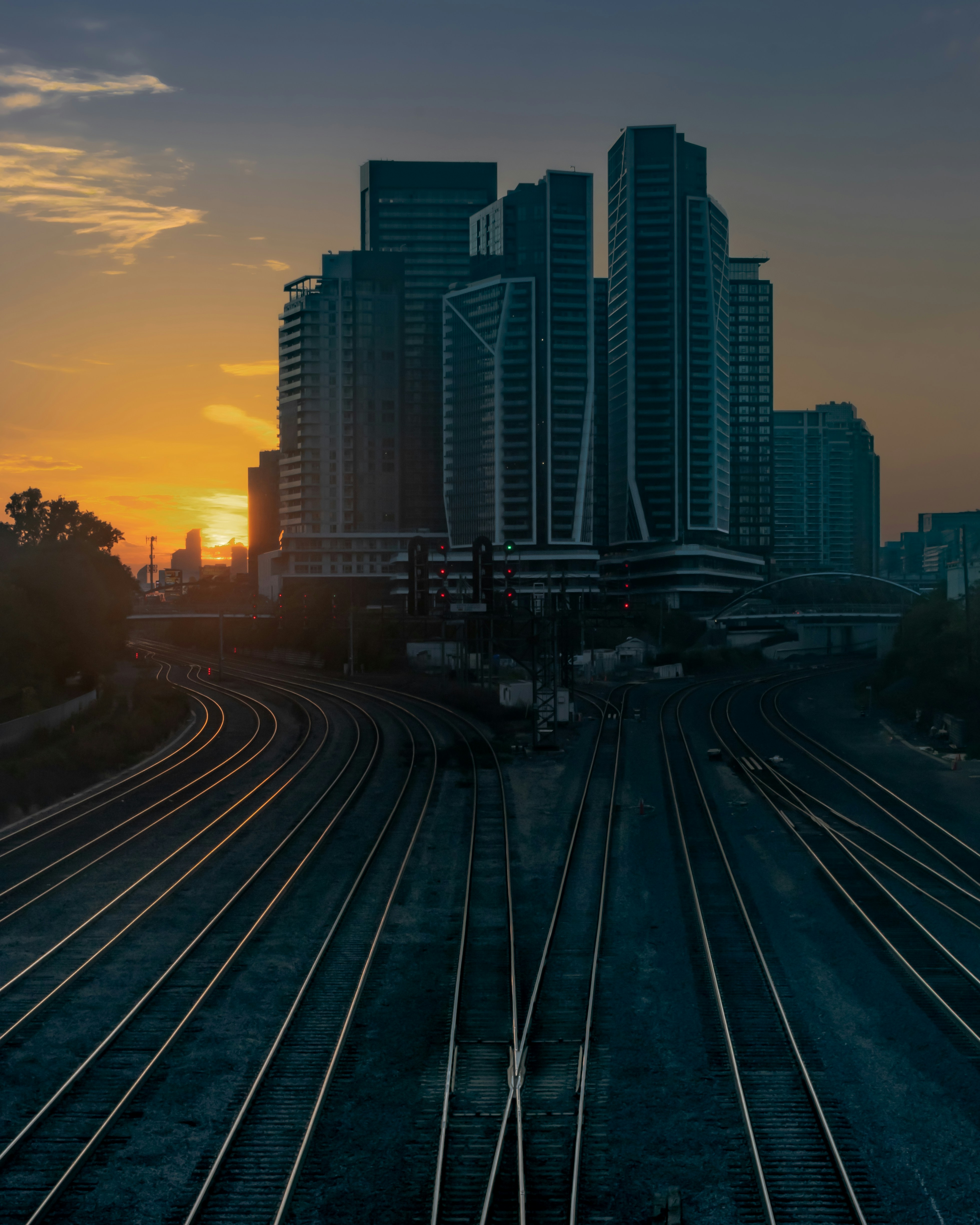 Sunset Over City Rails: A Converging Wake of Tracks Beneath Skyscrapers