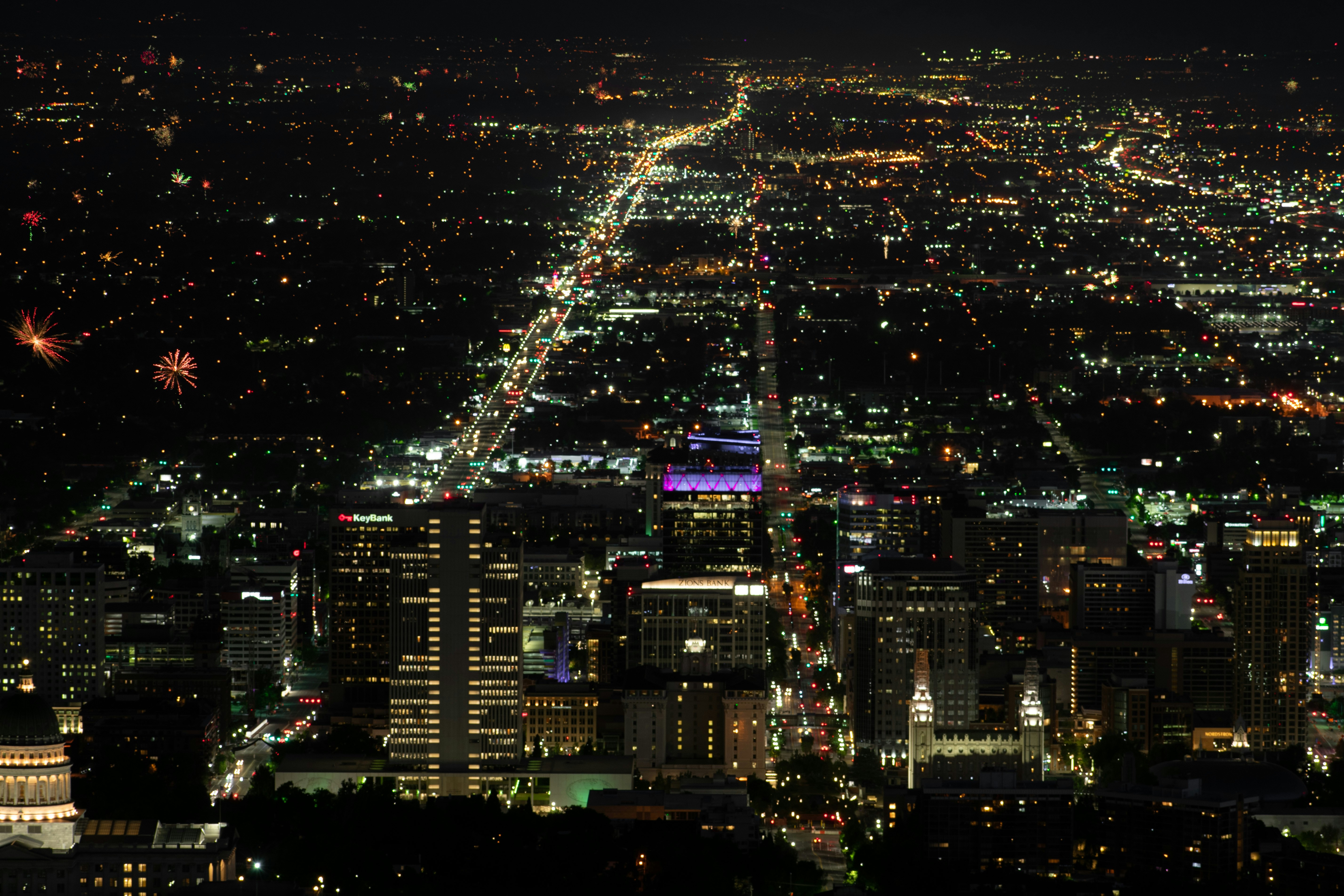 Neon Spine Over a City: Nightscape with Fireworks