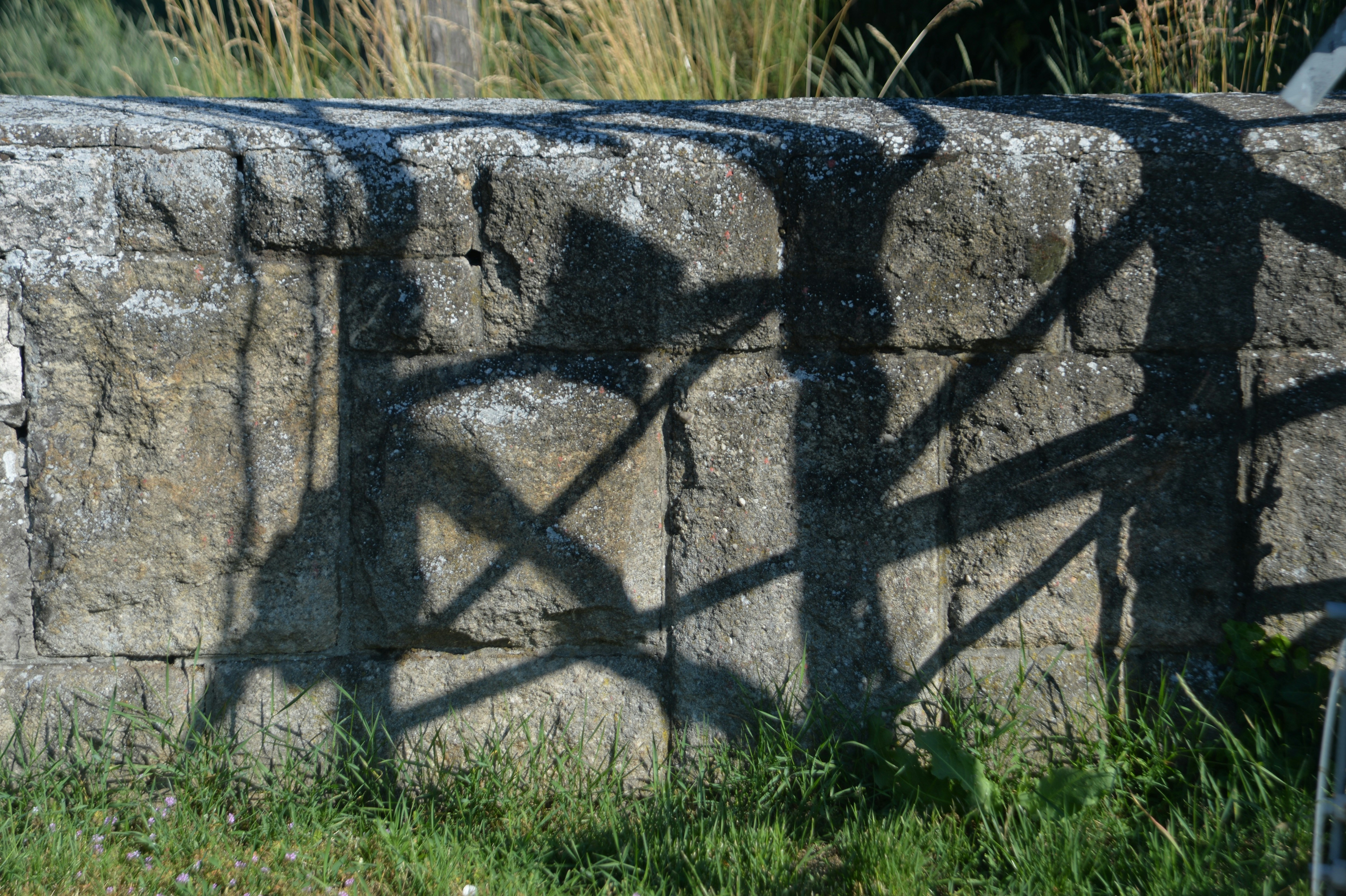 Shadowframe on Weathered Stone: Bicycle Silhouette Across a Sunlit Wall