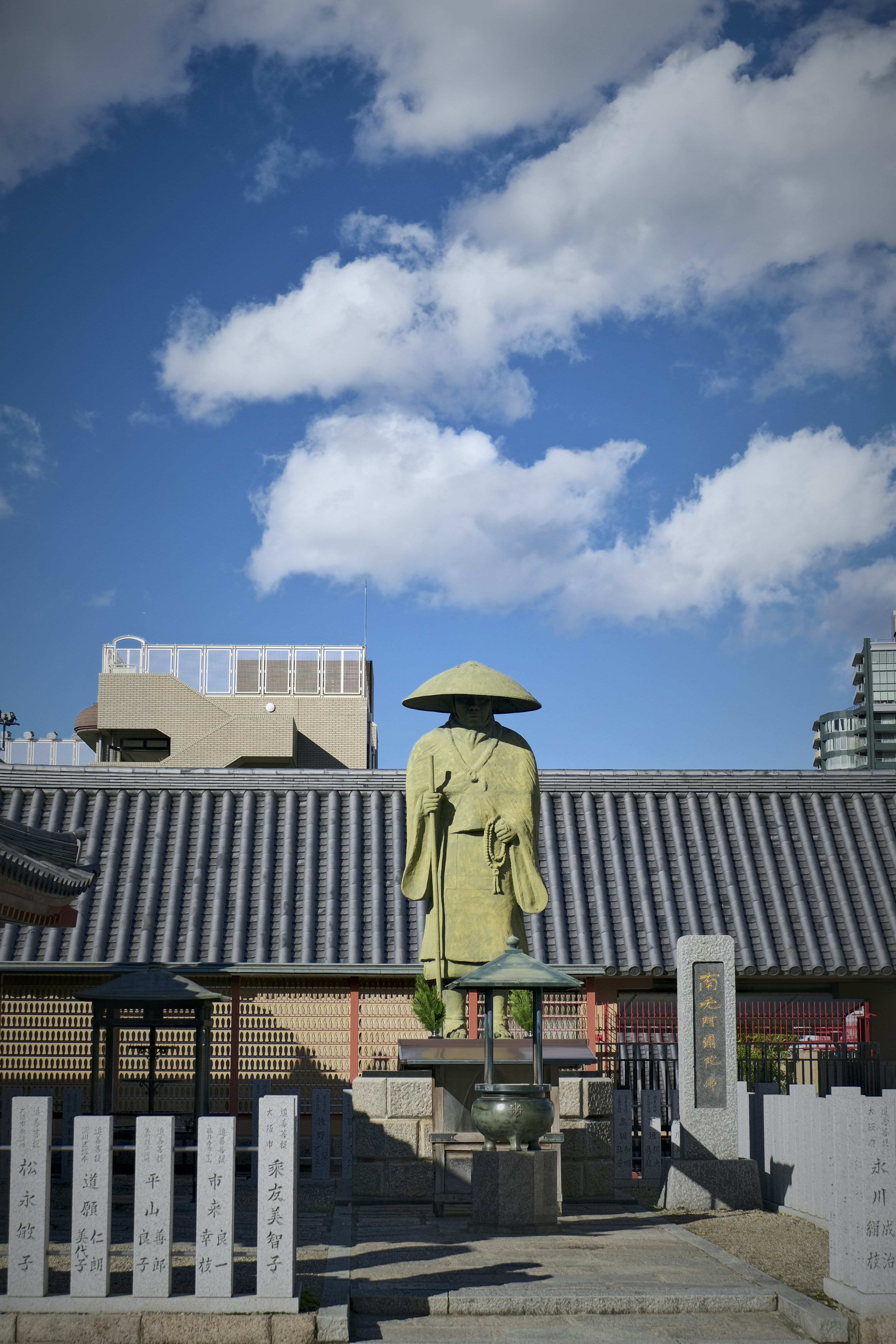 Stone Guardian Overlook: A Monk Statue Framed by Tile and Sky