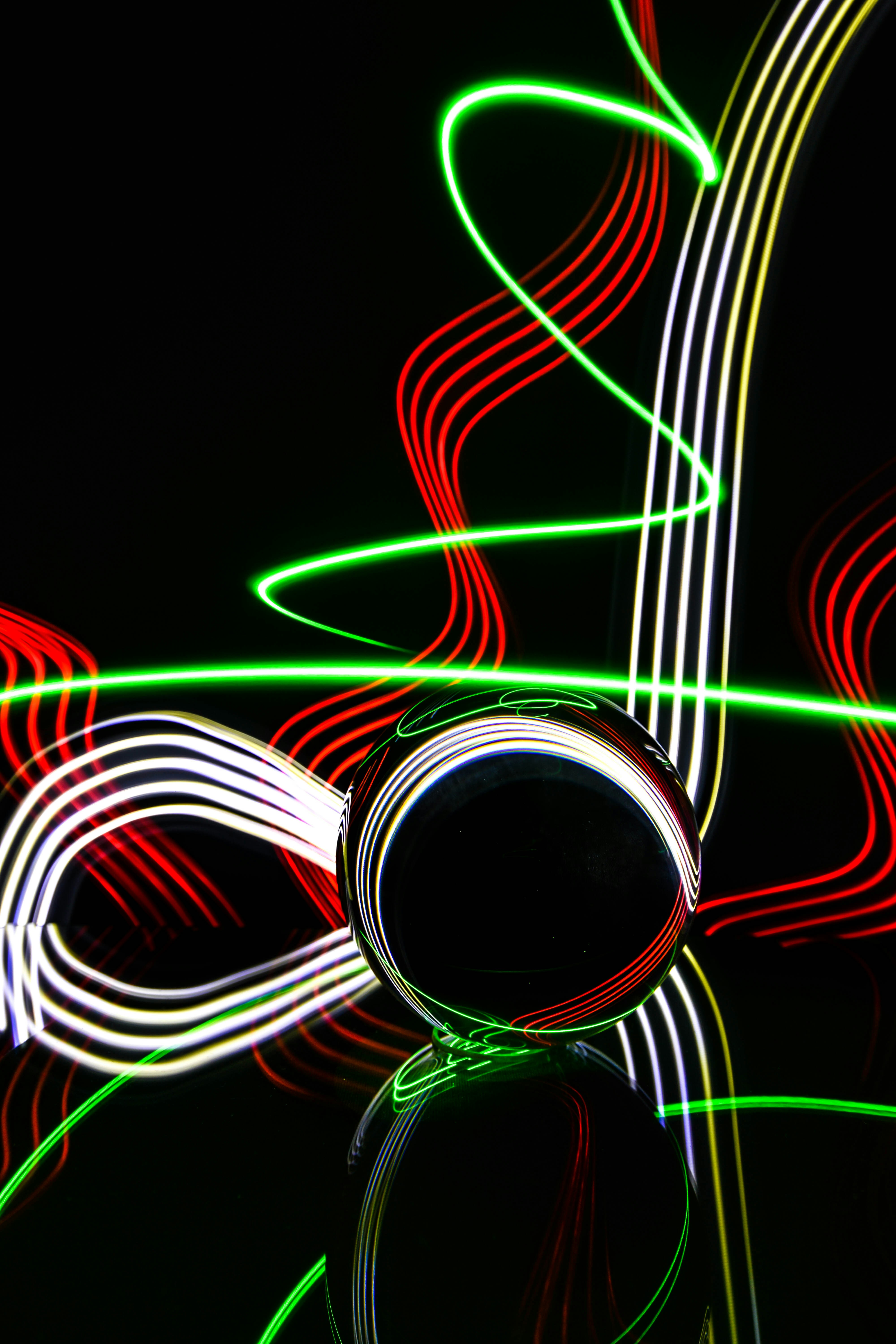 Neon Orb Ballet: Light Trails Converge on a Centered Reflective Sphere