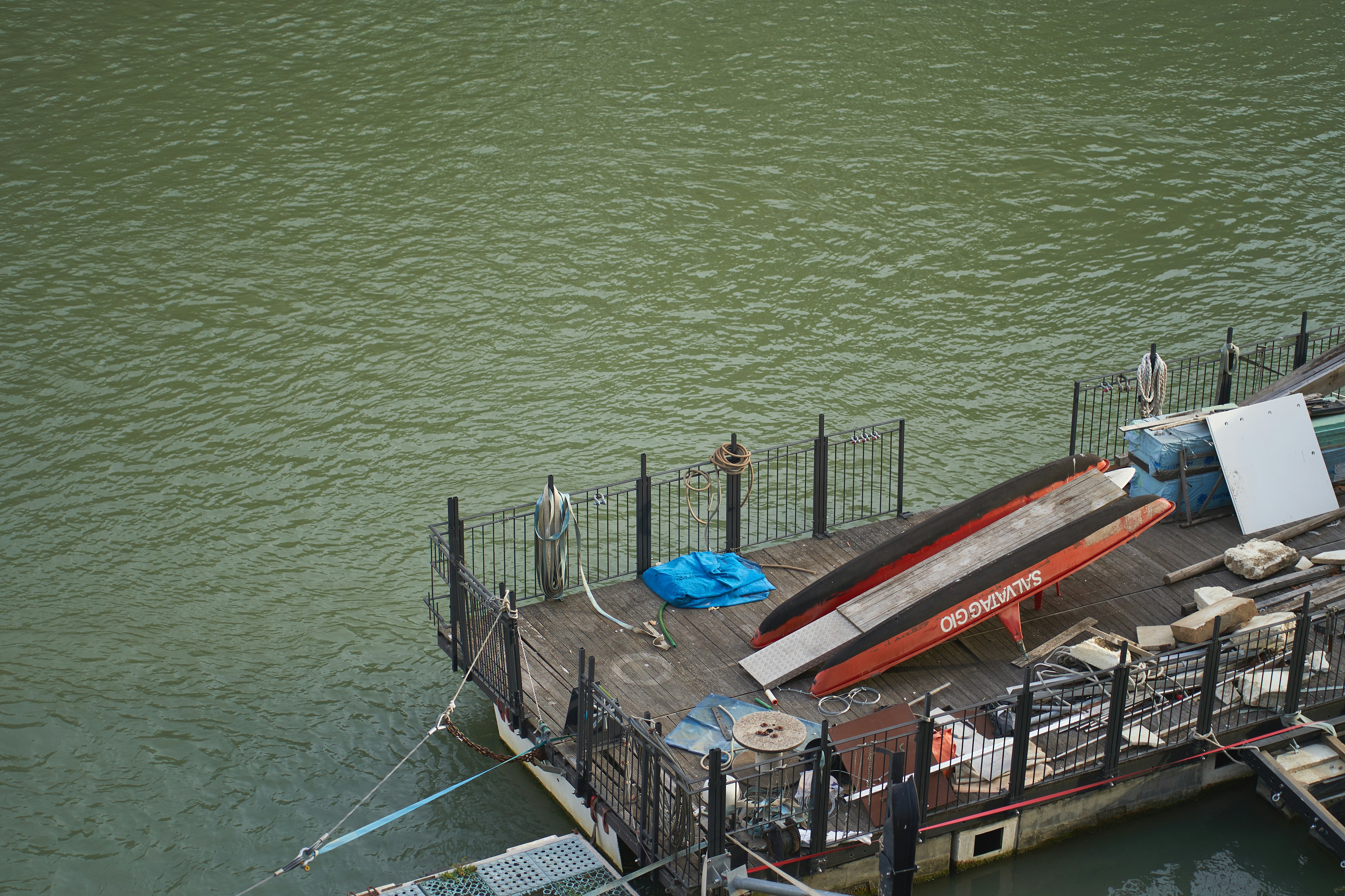 Red Lifeboat on a Weathered Wharf, Quiet Moorings by Green Water