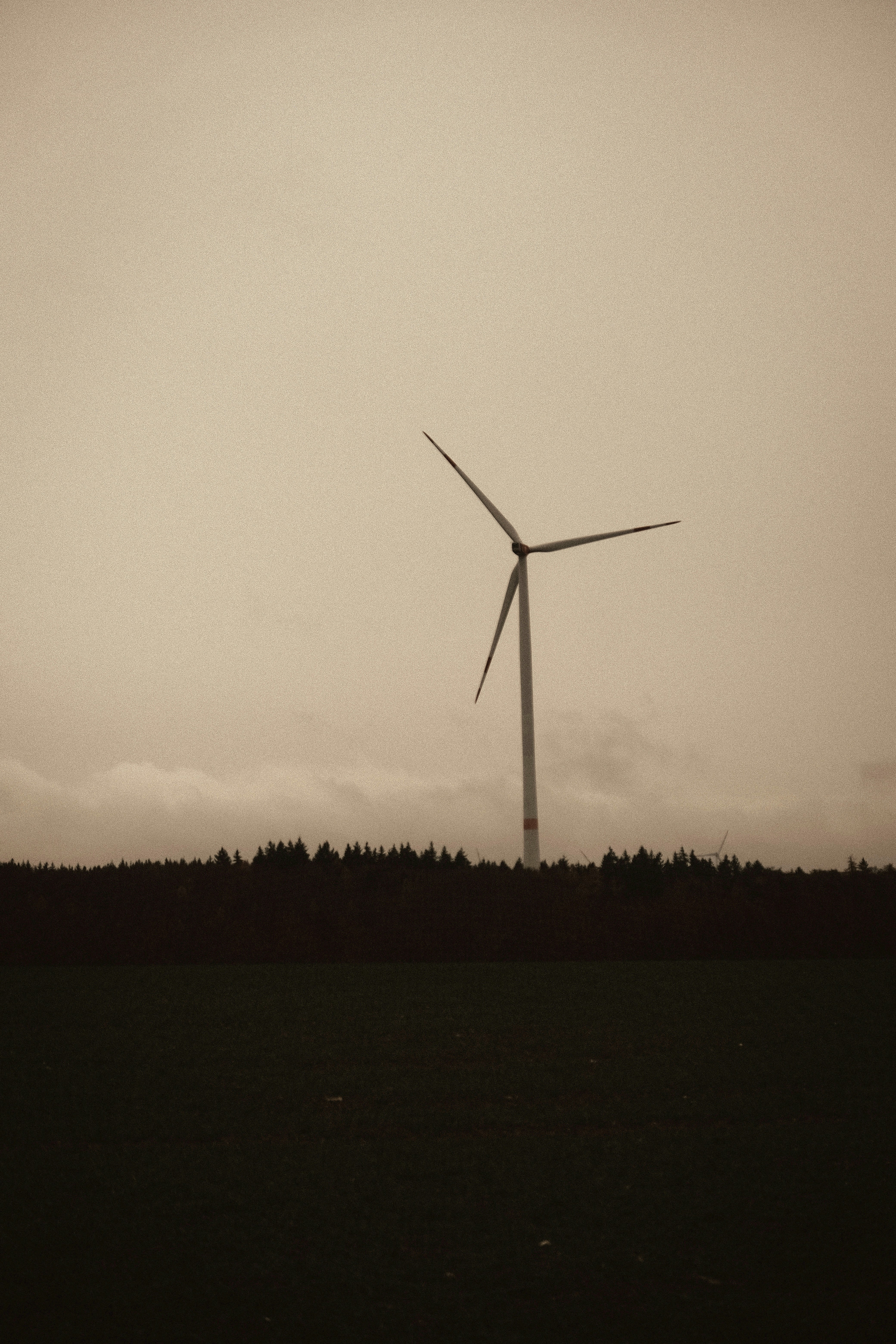 Sepia Dusk Over the Plain: The Wind Turbine's Silent Gaze