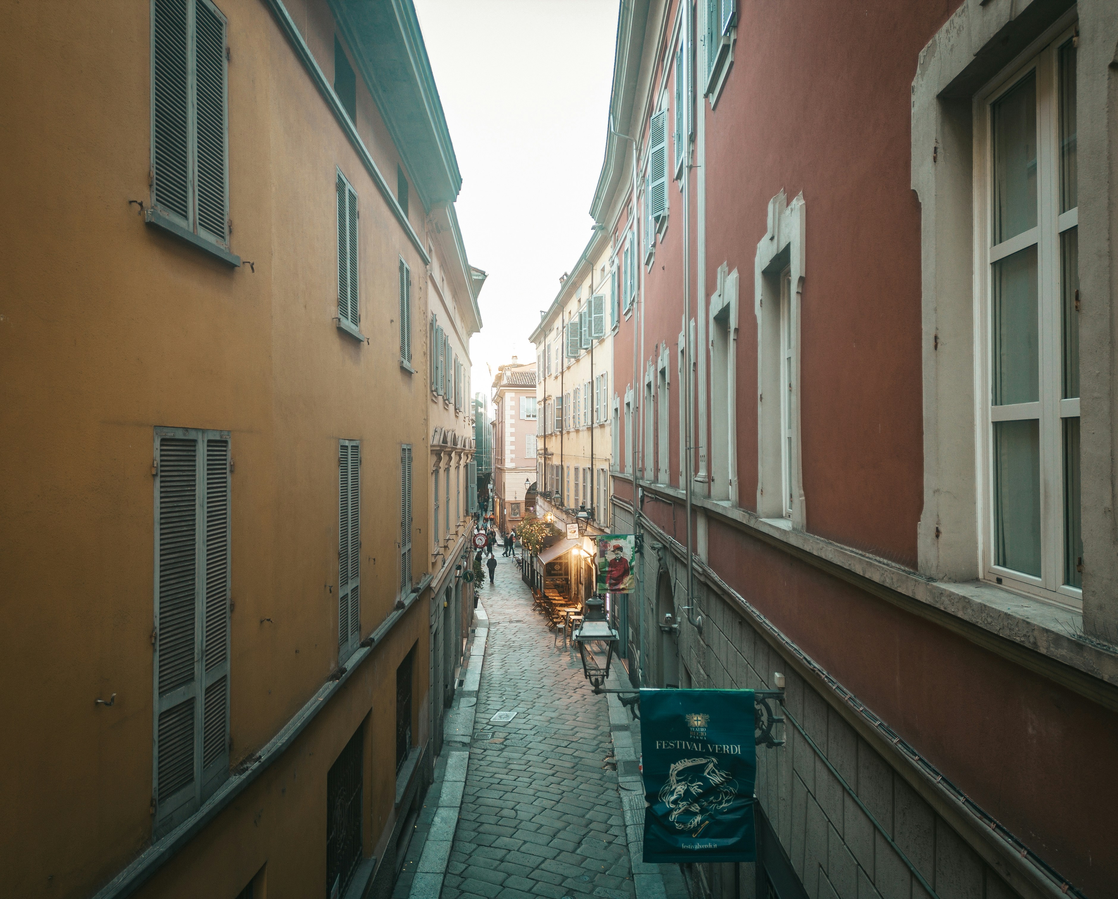 A narrow city street lined with tall buildings photo – Free Alleyway ...