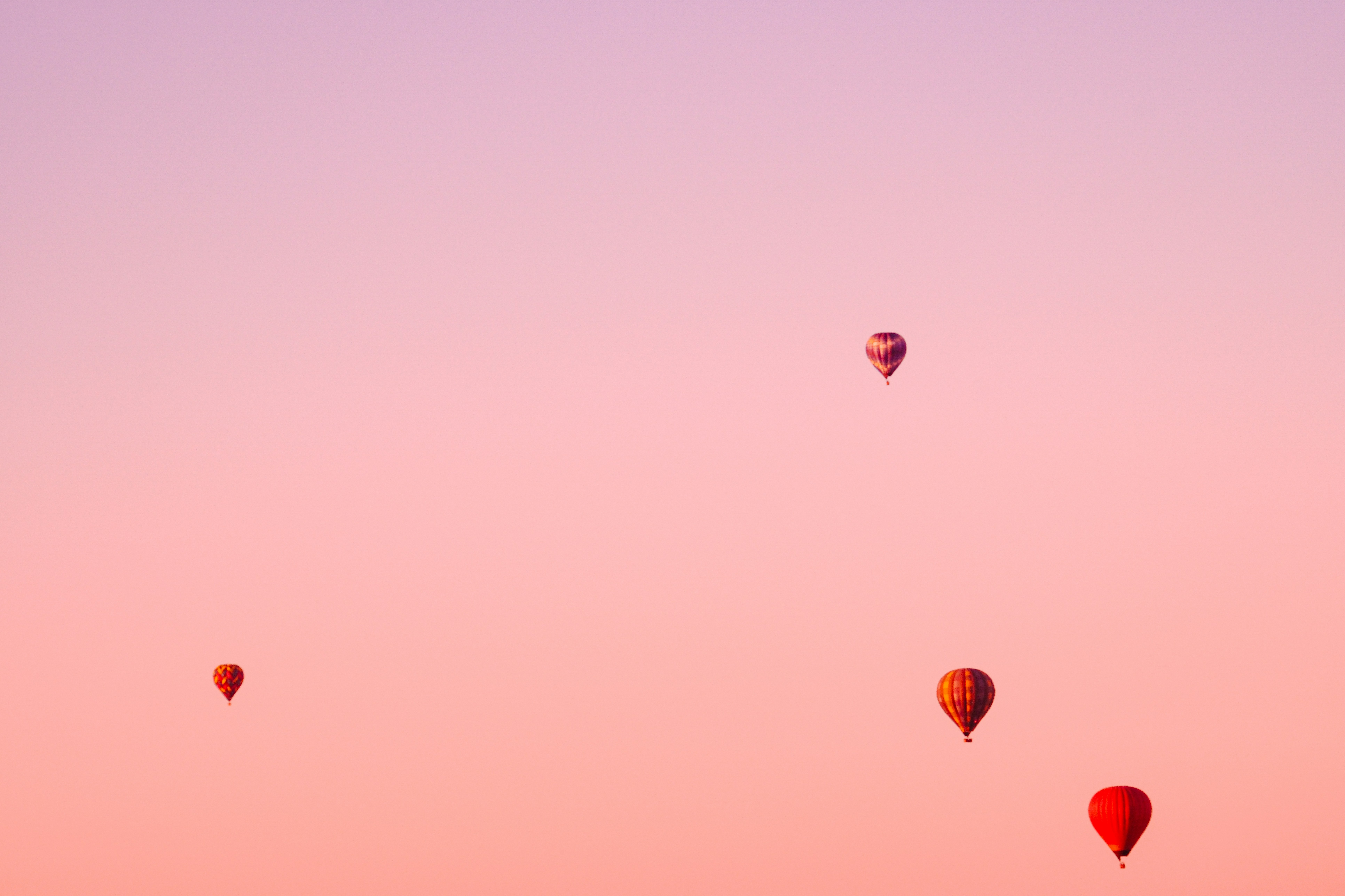 Five Silent Balloons Drifting Across a Peach Sky