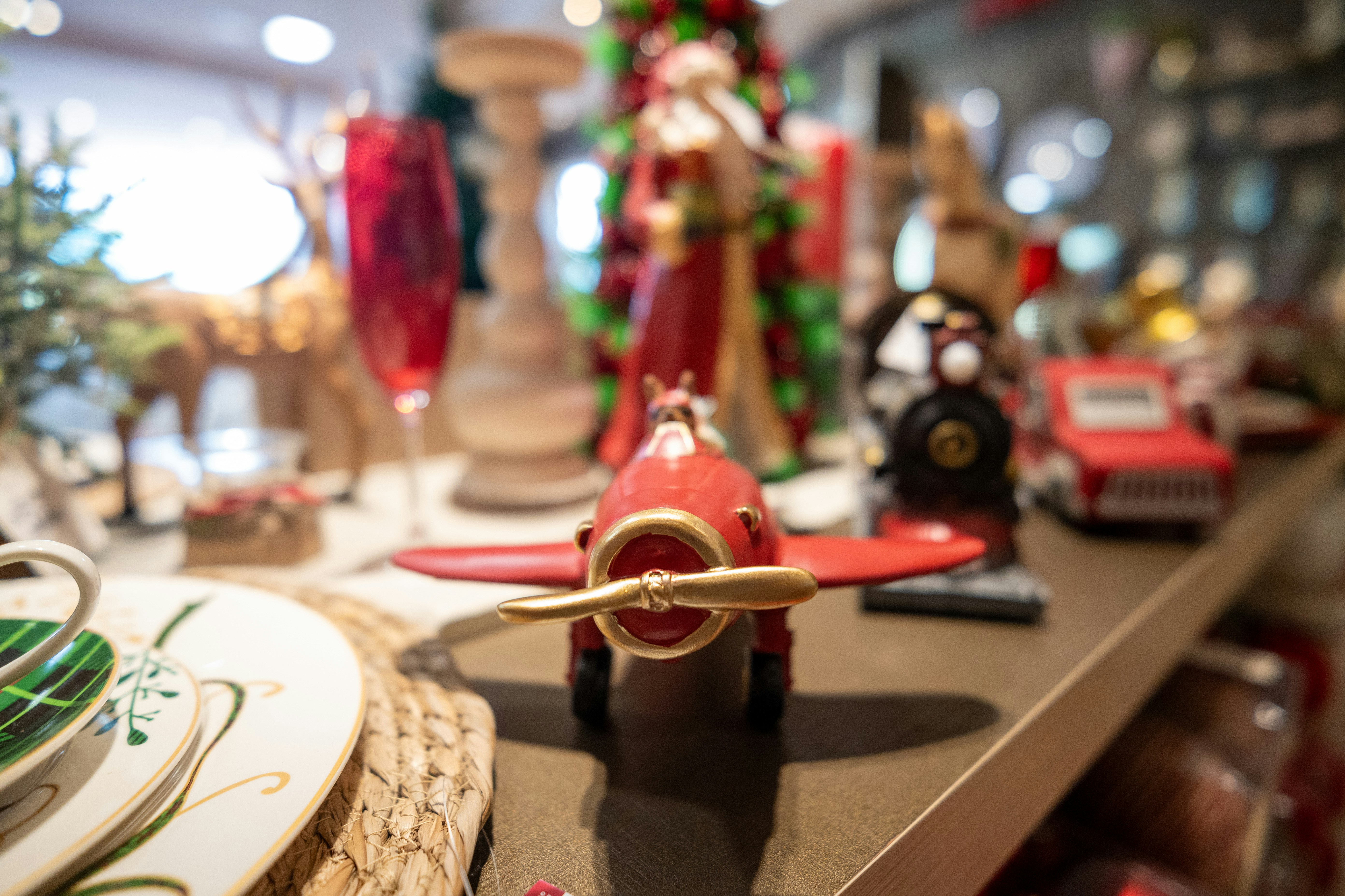 A red toy airplane sitting on top of a table photo – Free Poinsettia ...